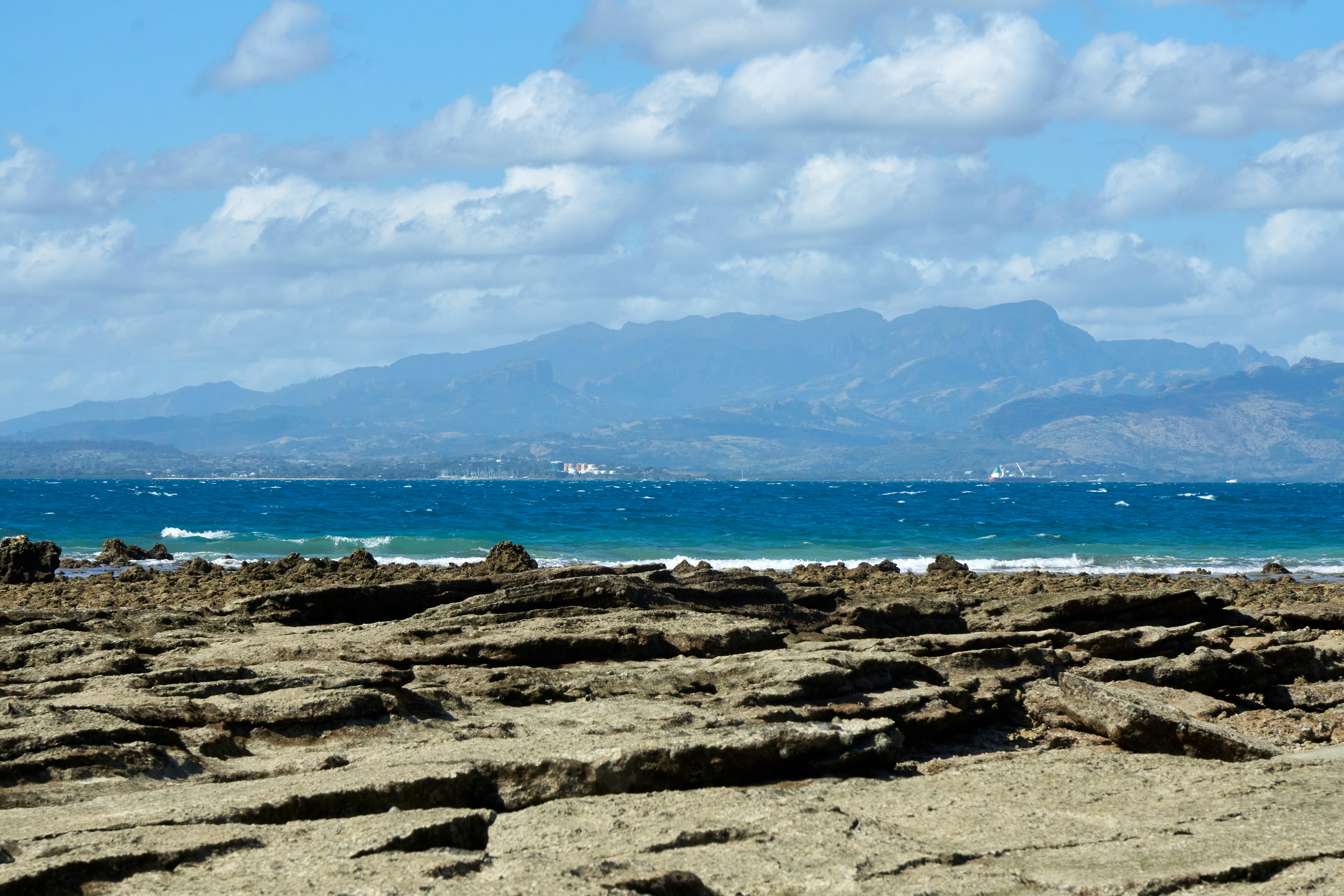 A beach with a body of water and mountains in the background photo – Free Beach Image on Unsplash