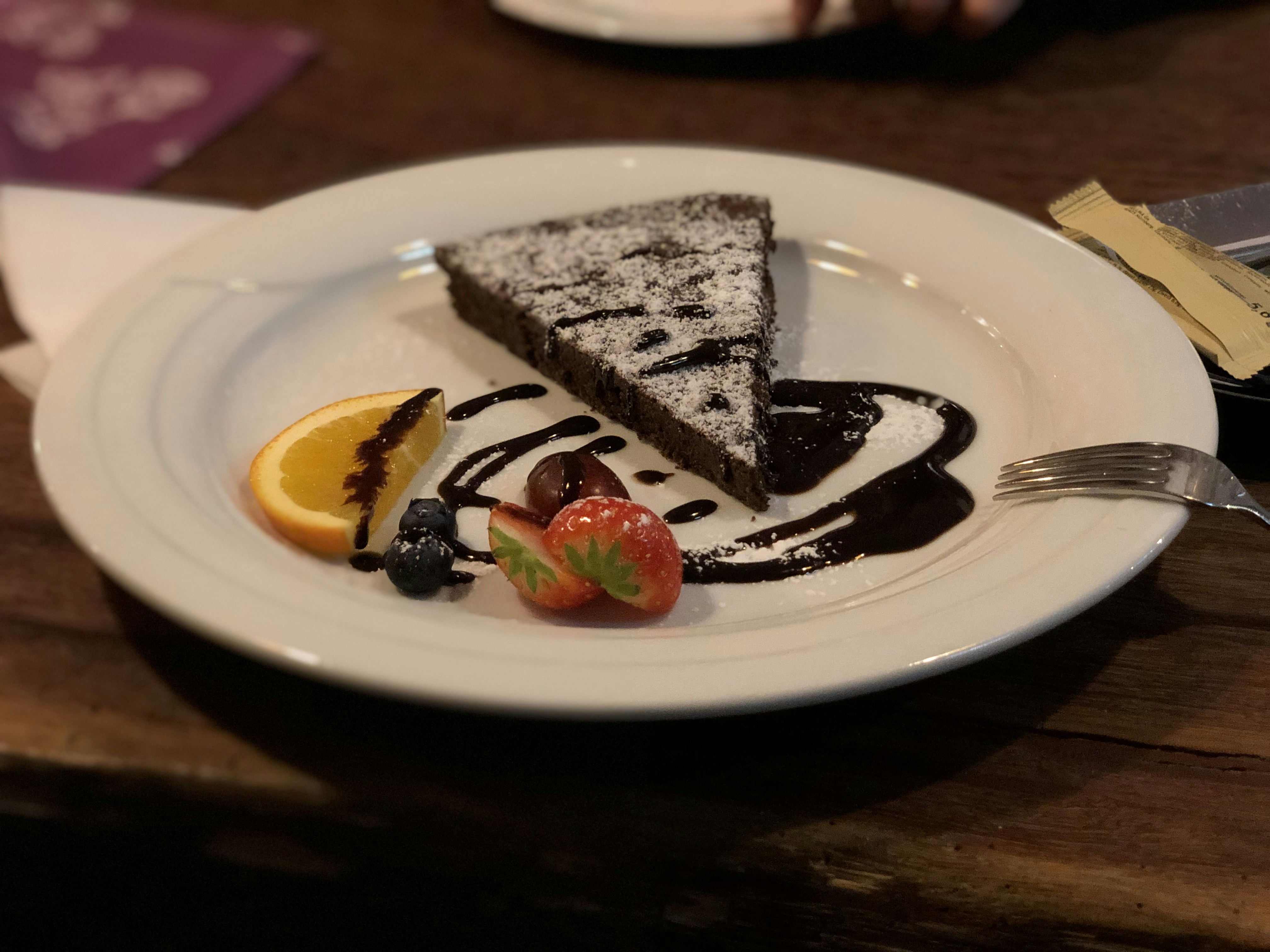 Powdered Chocolate Slice on a Rustic Plate: Citrus and Berry Accents