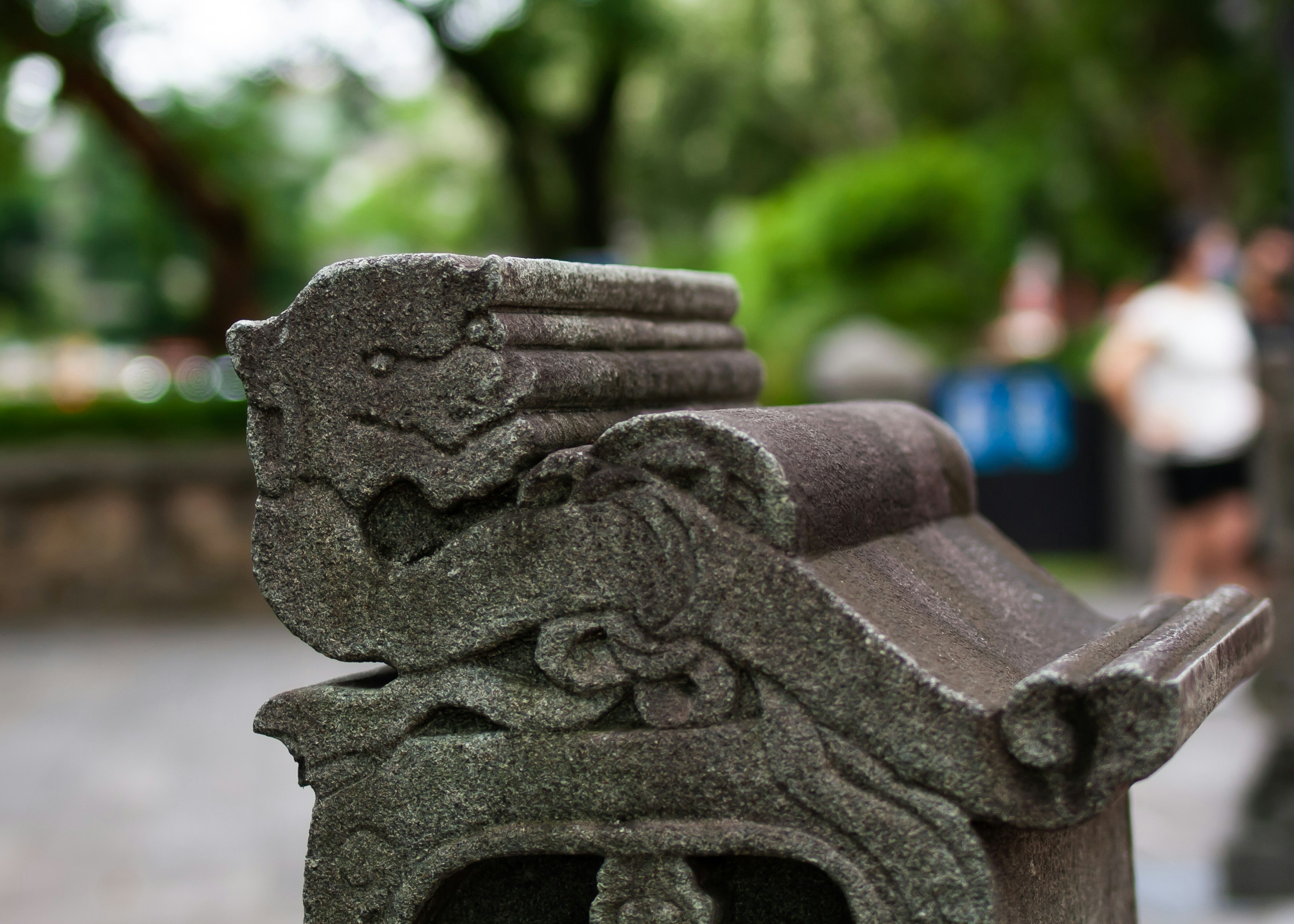 Weathered Stone Guardian in a Park: Close-Up of Intricate Carvings