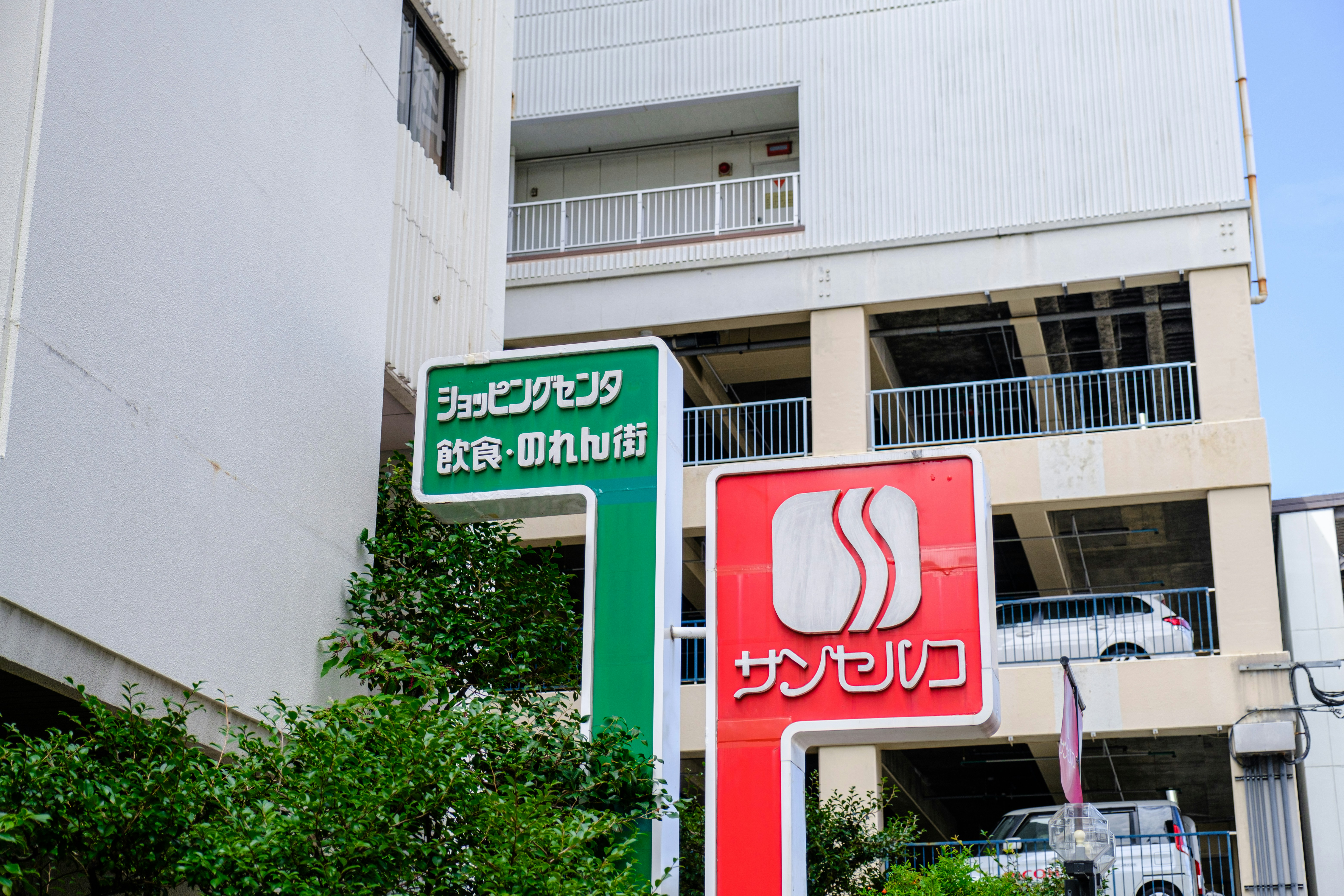 Red S-Logo Anchored by Green Signage in a Sunlit Urban Facade