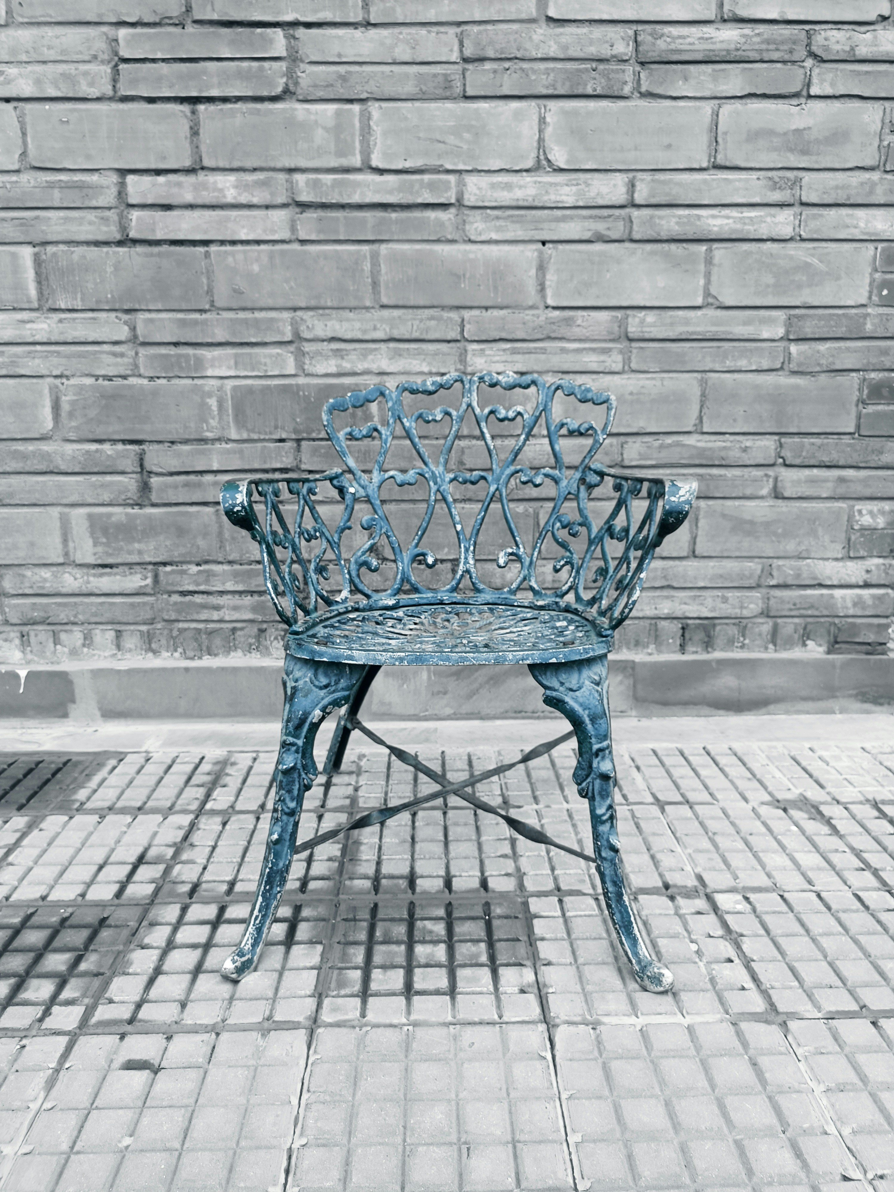 a blue chair in front of a brick wall