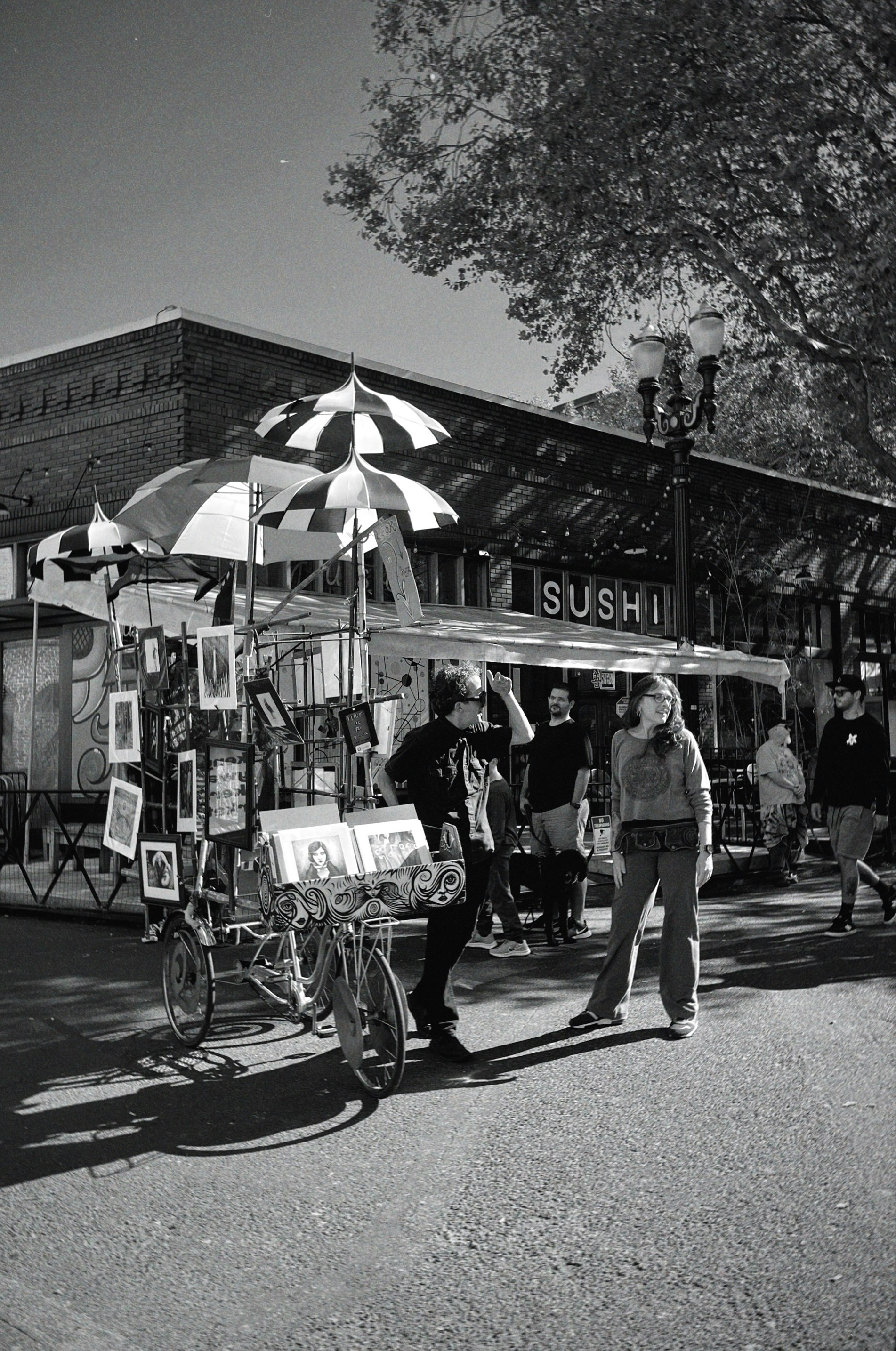 Monochrome Street Cart: Umbrellas, Frames, and Foot Traffic