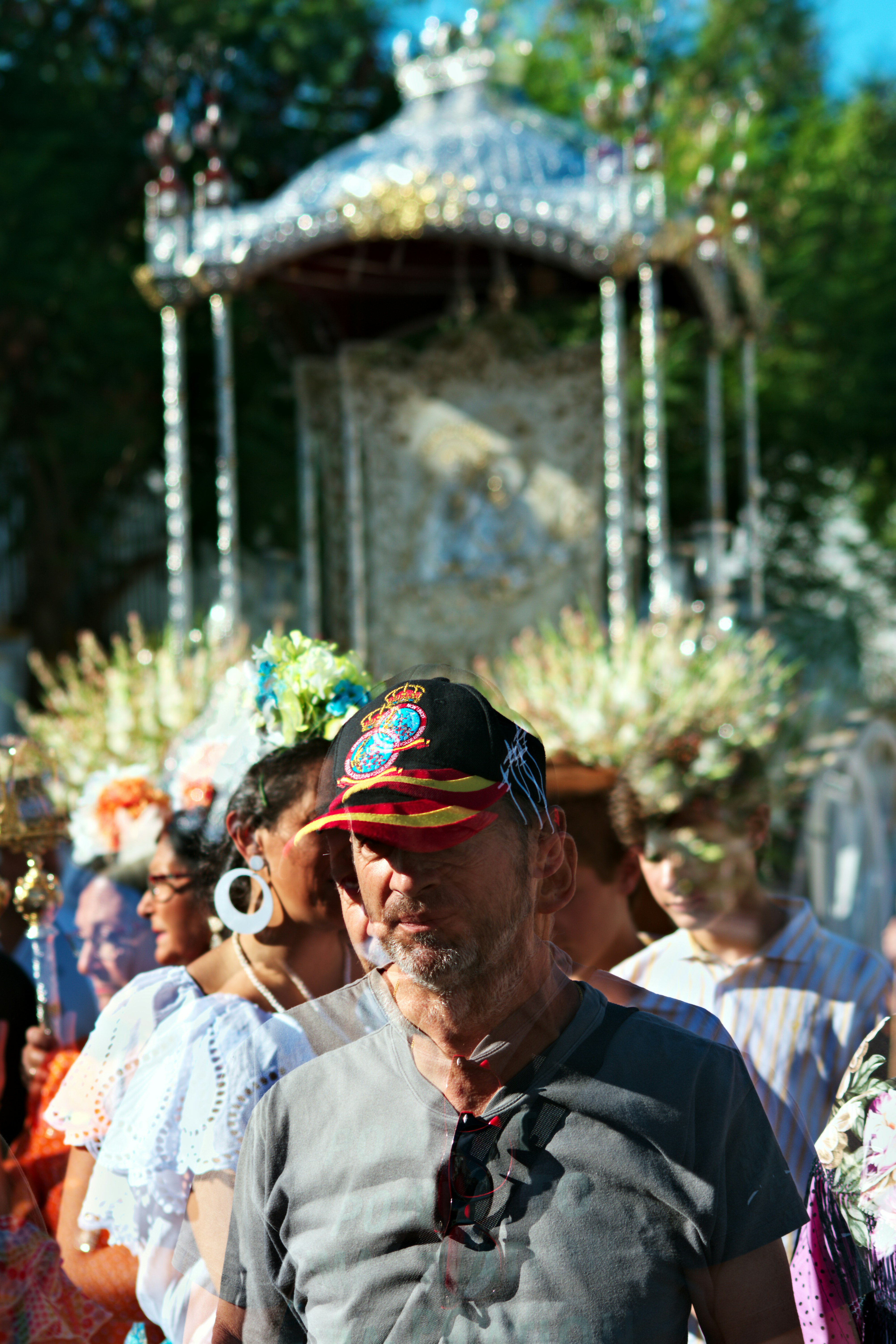 Cap in the Crowd: A sunlit portrait amid a lively festival procession