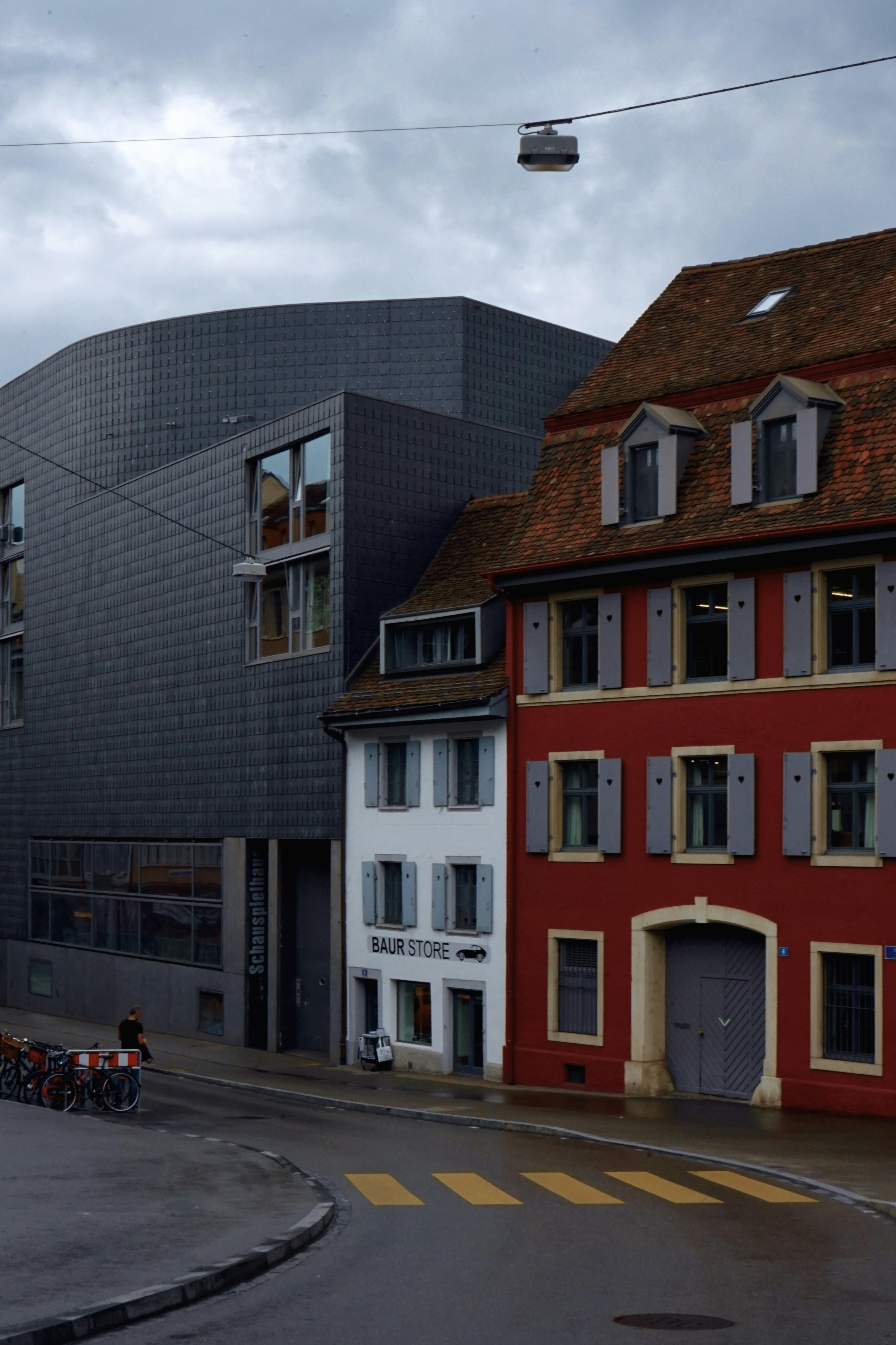 Un bâtiment avec une rue et une personne qui passe devant photo – Image ...