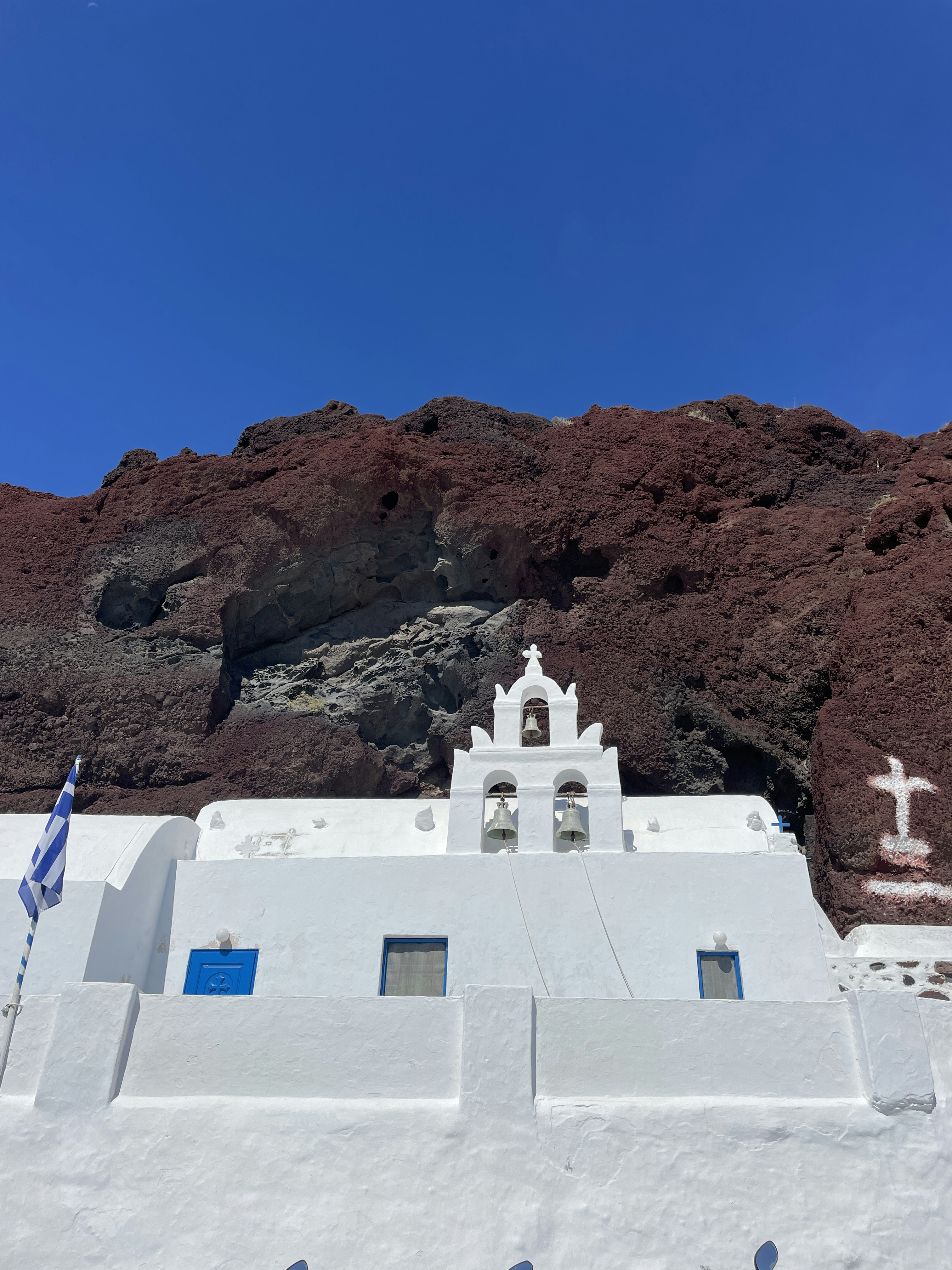 White Chapel Against Lava: A Quiet Shrine at the Edge of the Cliff