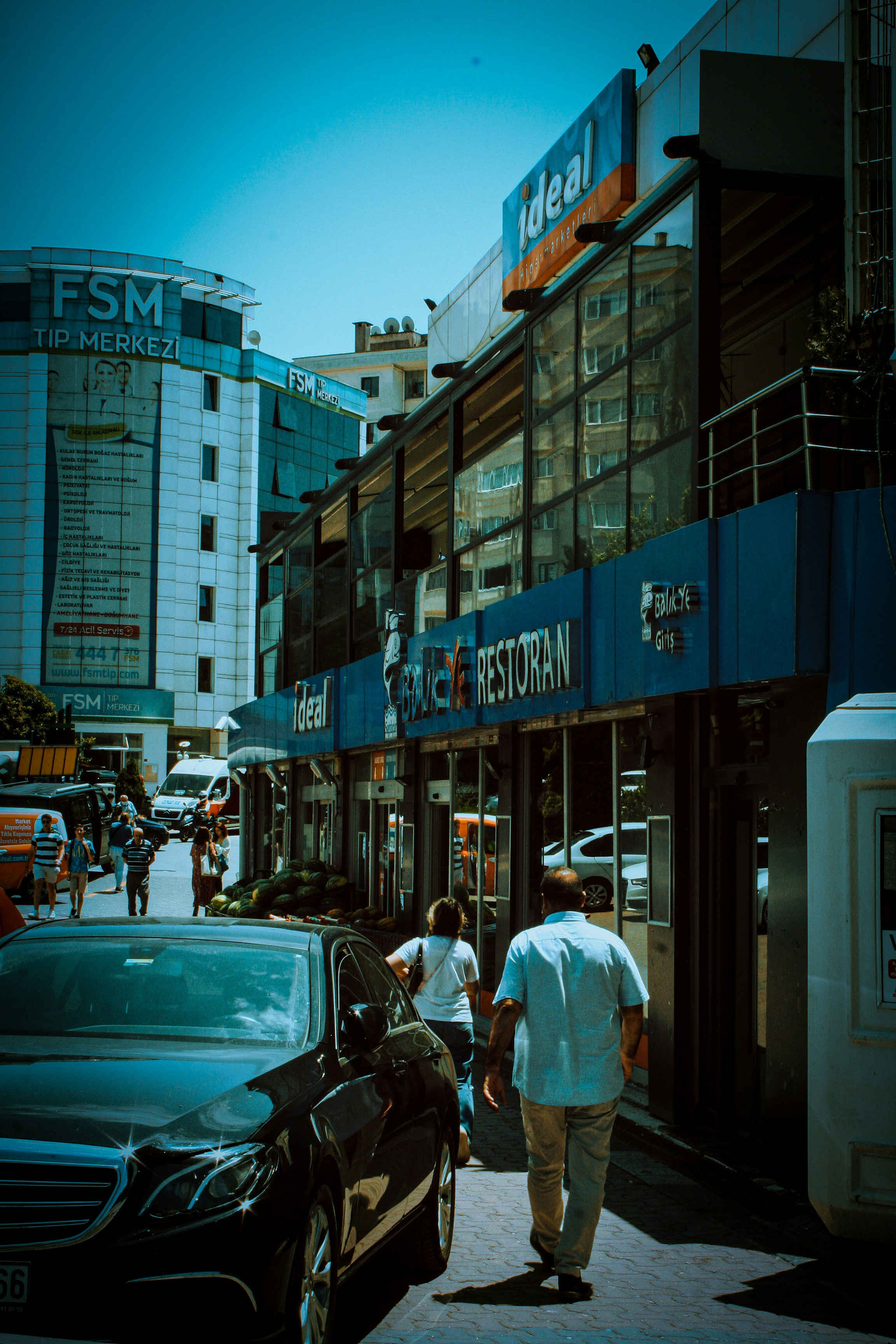 Blue-Hued Boulevard: Pedestrians and Glass Facades in Motion