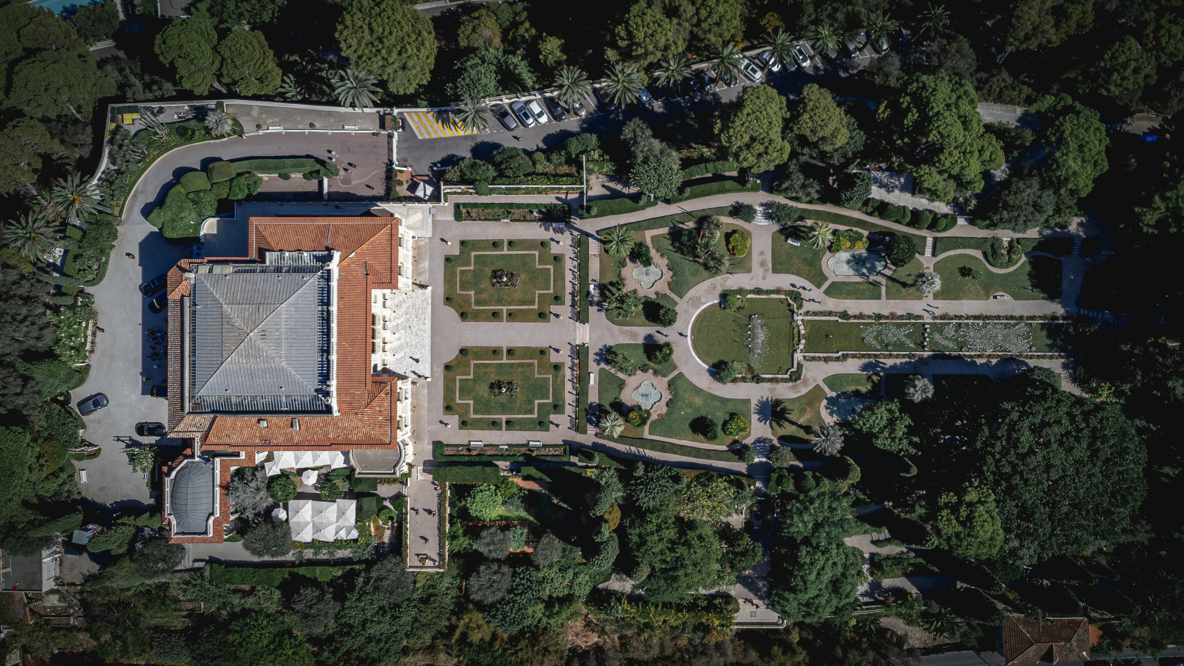 A large building with a pool in the middle of a green field photo ...
