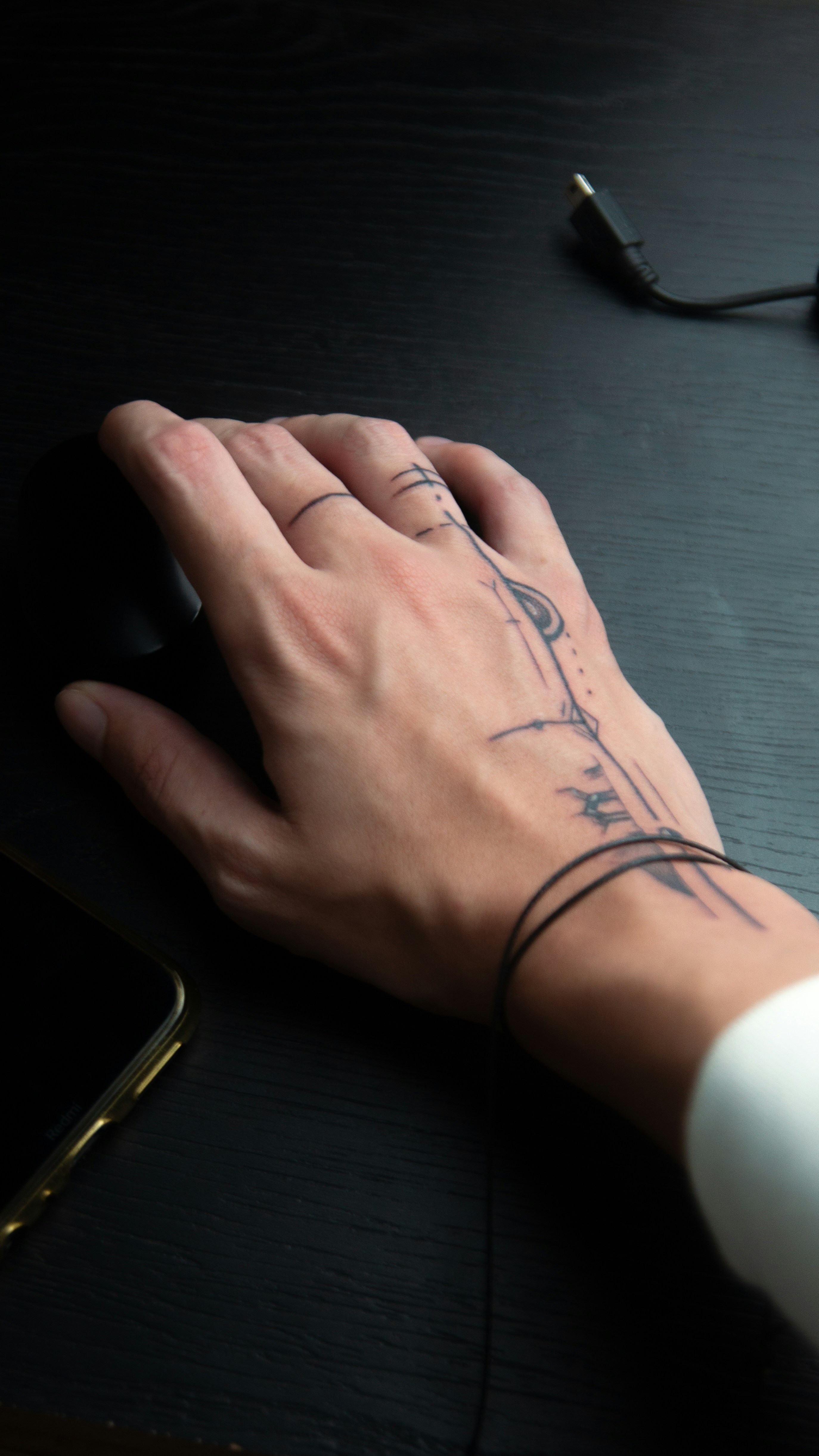 Ink Ledger: A Tattooed Hand at Rest on a Minimalist Desk