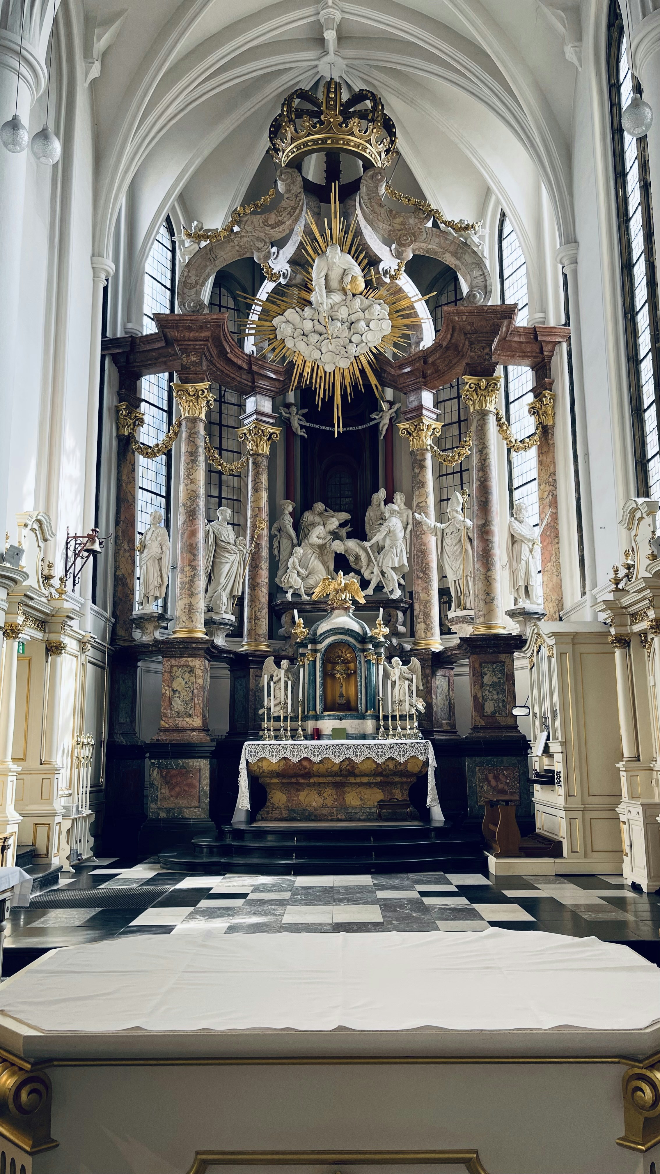Intricate altar adorned with sculptures and gold accents in a historical church setting. The architectural details reflect a blend of artistry and spirituality.