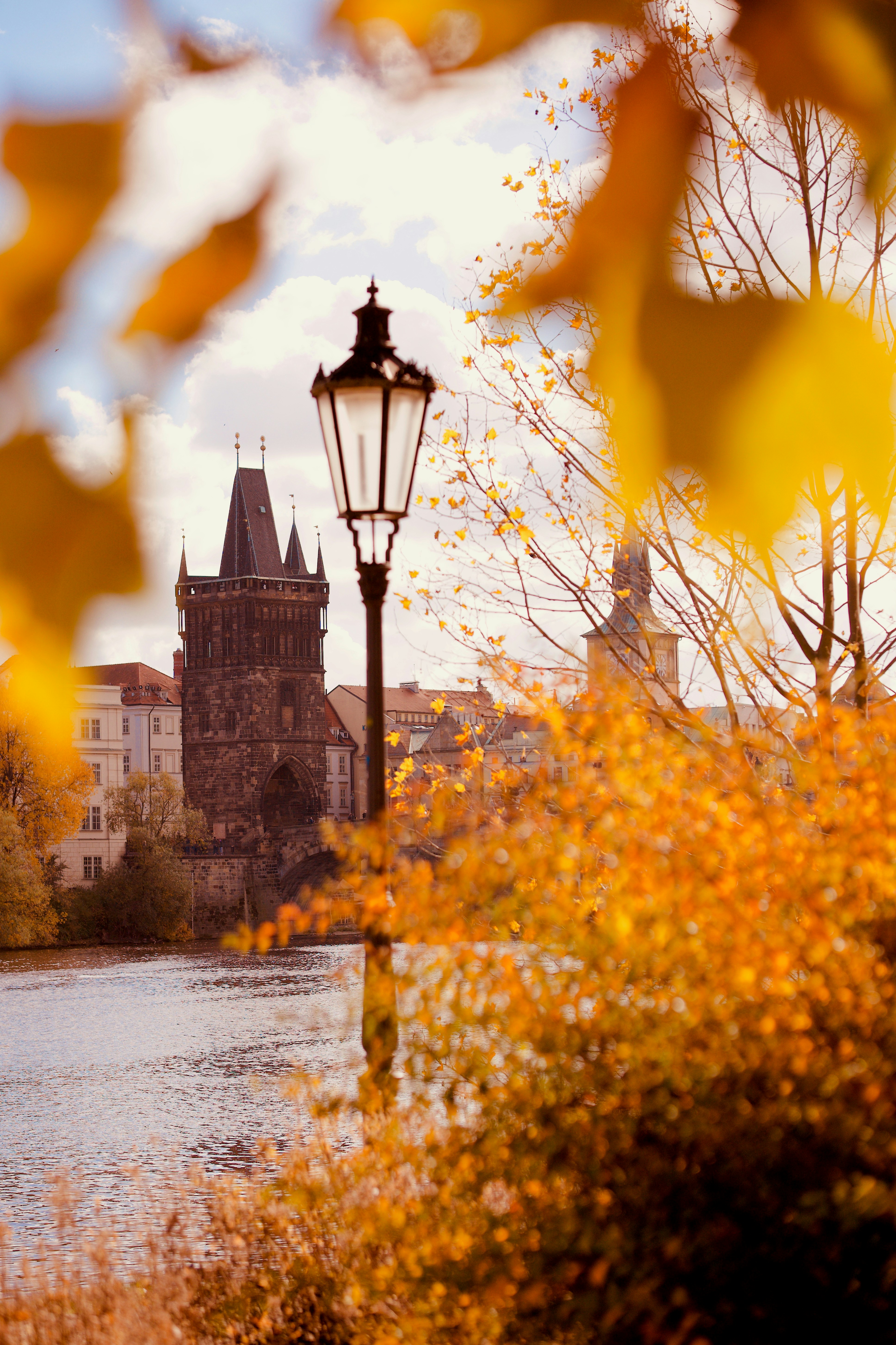 Autumn Lantern Framing a Medieval Bridge Tower Over the River