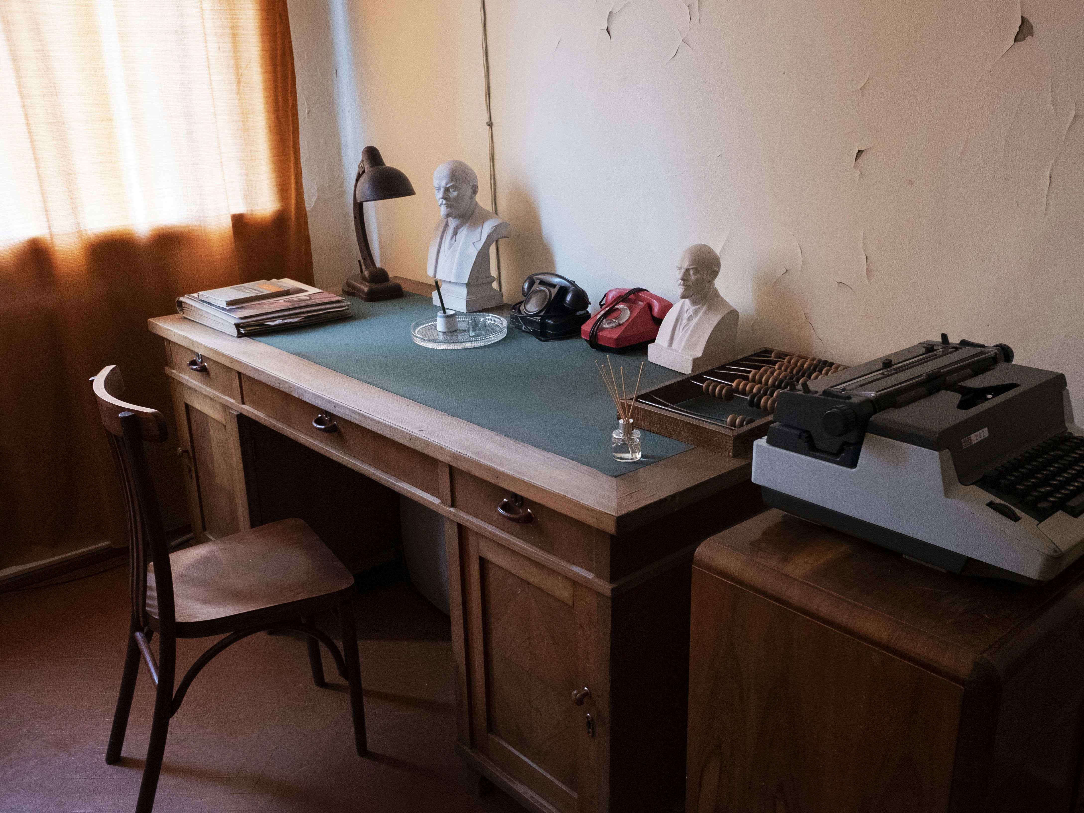 A desk with a computer and statues on it photo – Free ...