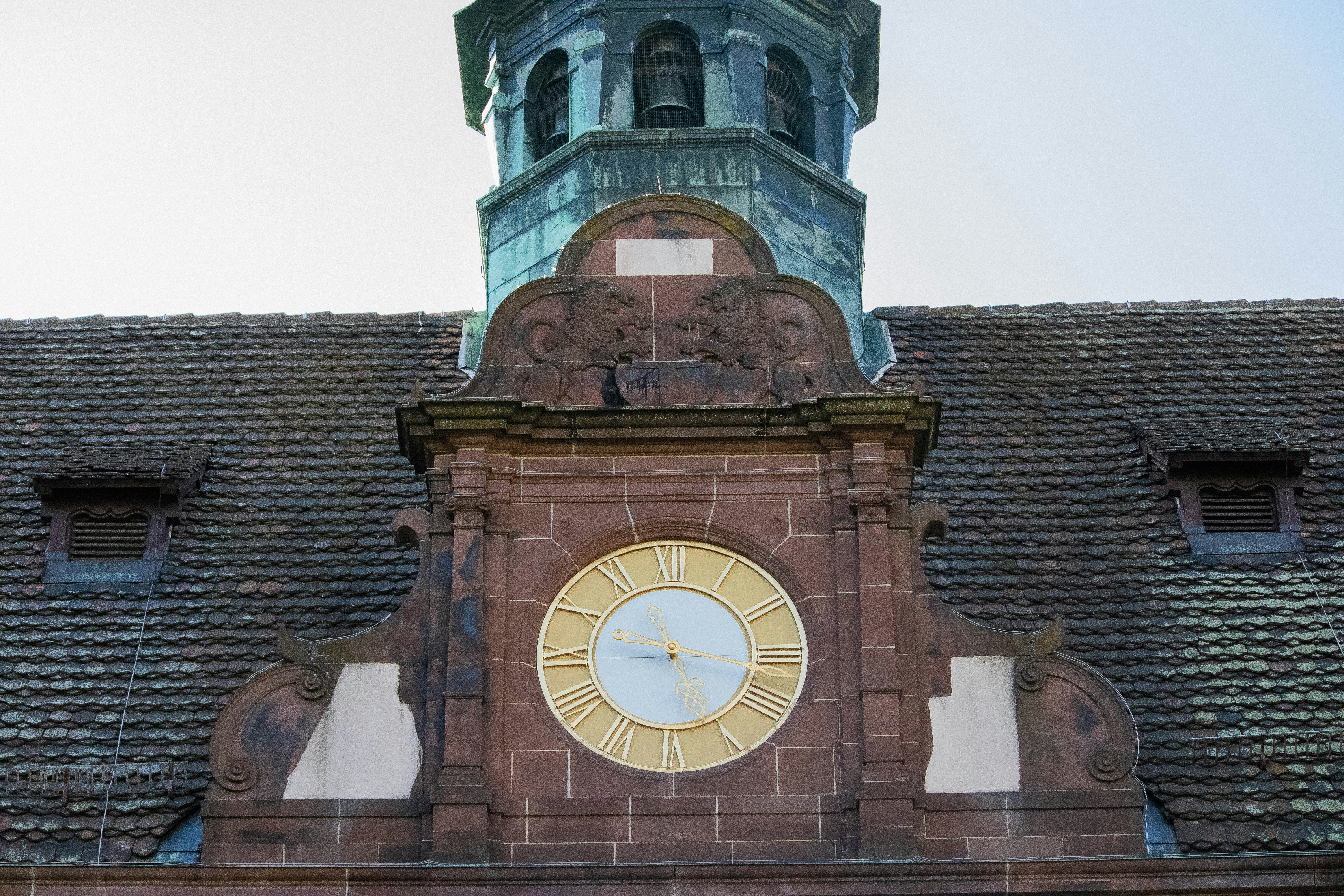 Timekeeper's Facade: Clock Tower in Weathered Brick and Copper