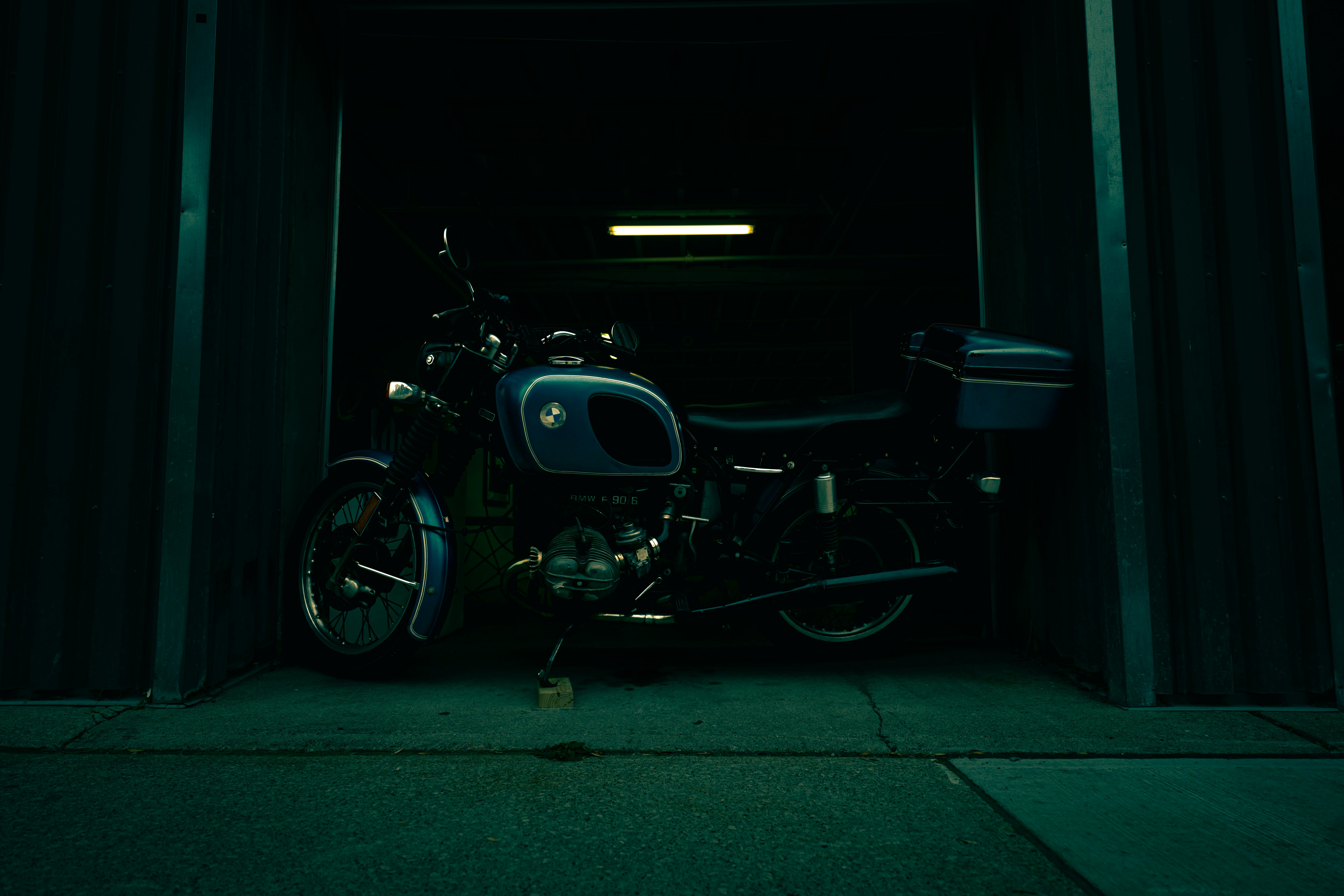 Teal-Shadow Ride: A Vintage Motorcycle Quietly Resting in a Dim Garage