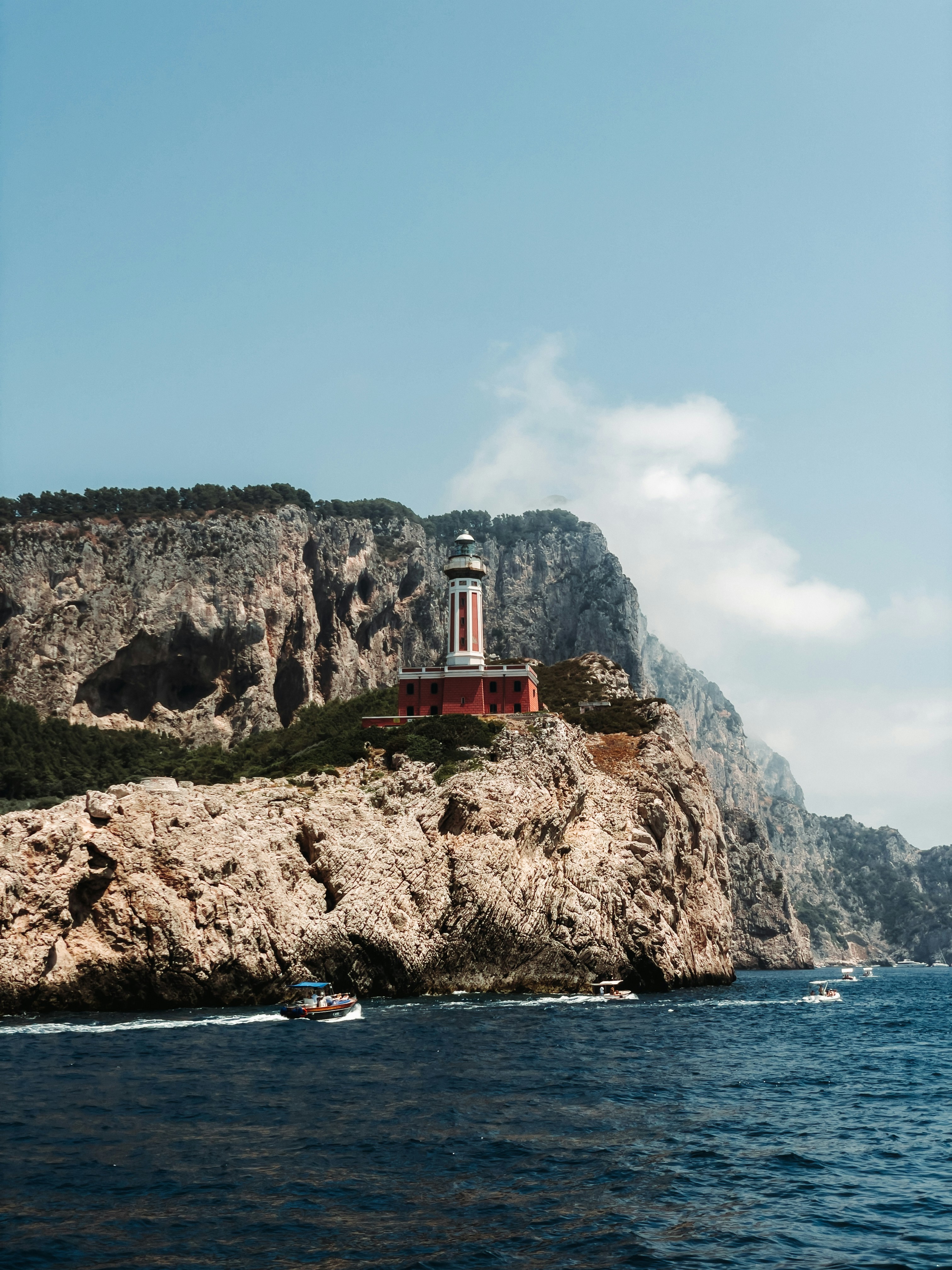 A lighthouse on a rocky island photo – Free Watchtower Image on Unsplash