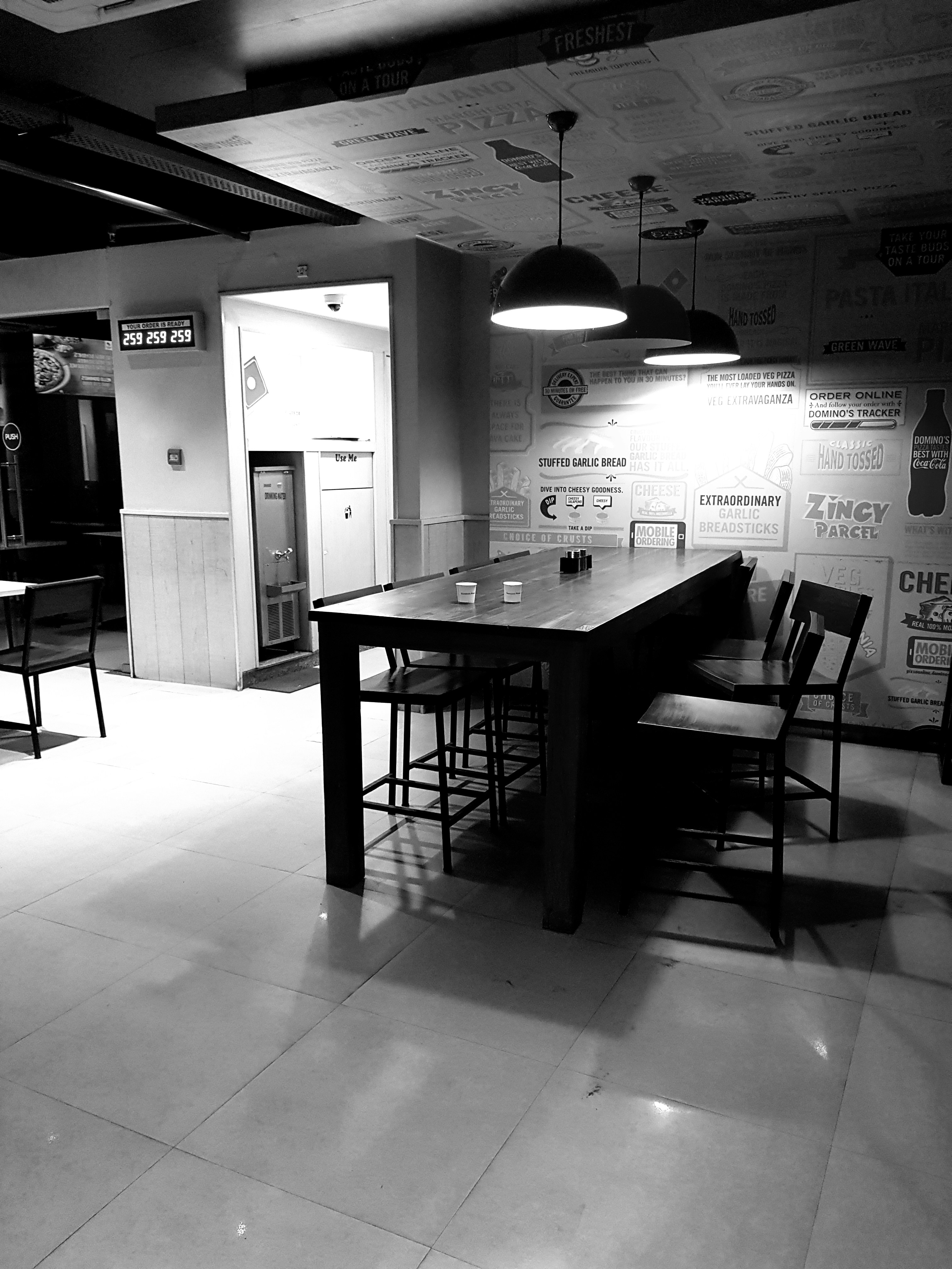 Monochrome Centerpiece: A Long Table Anchors a Dim Café