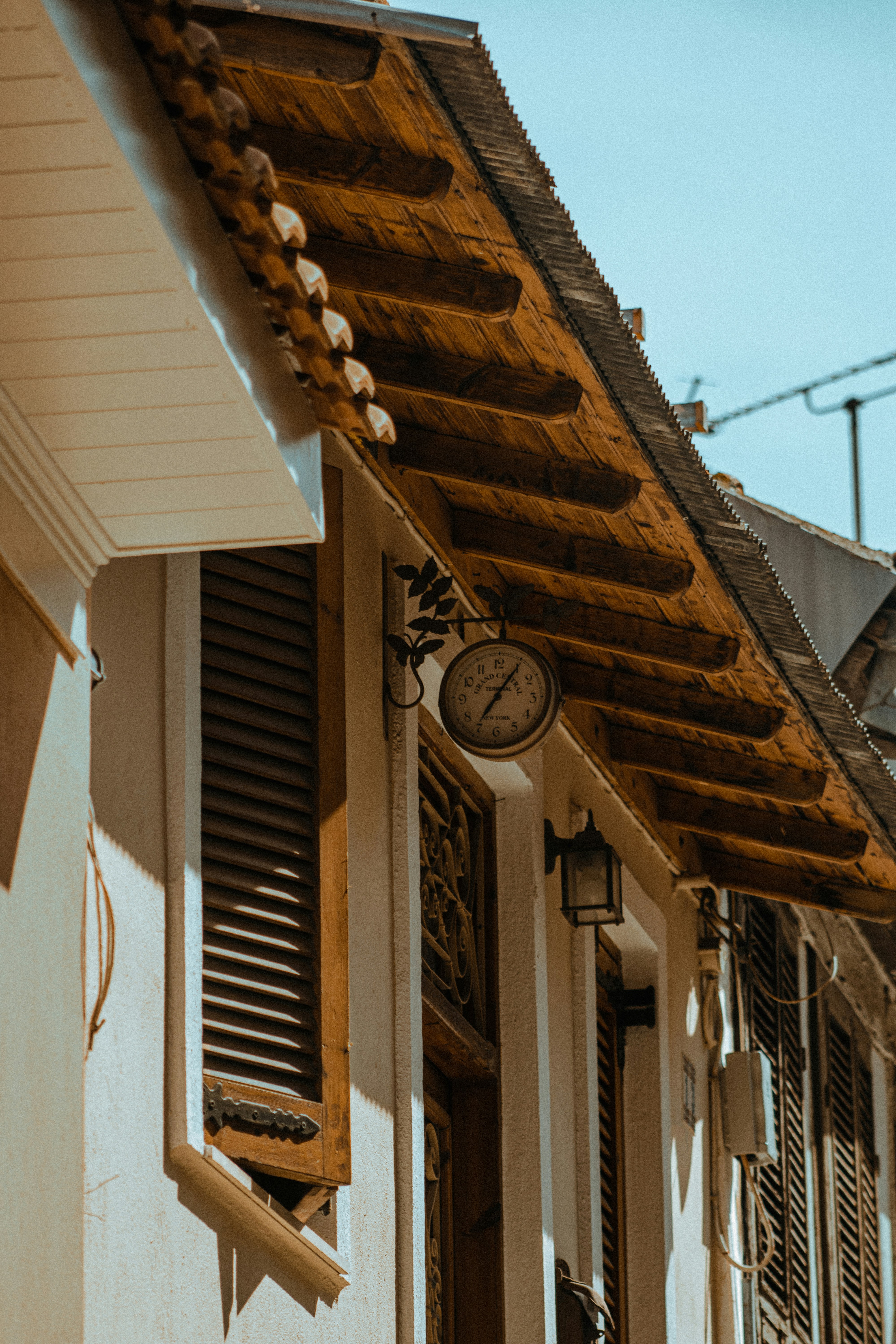 Timekeeper Beneath Rustic Eaves: A Quiet, Shuttered Alley