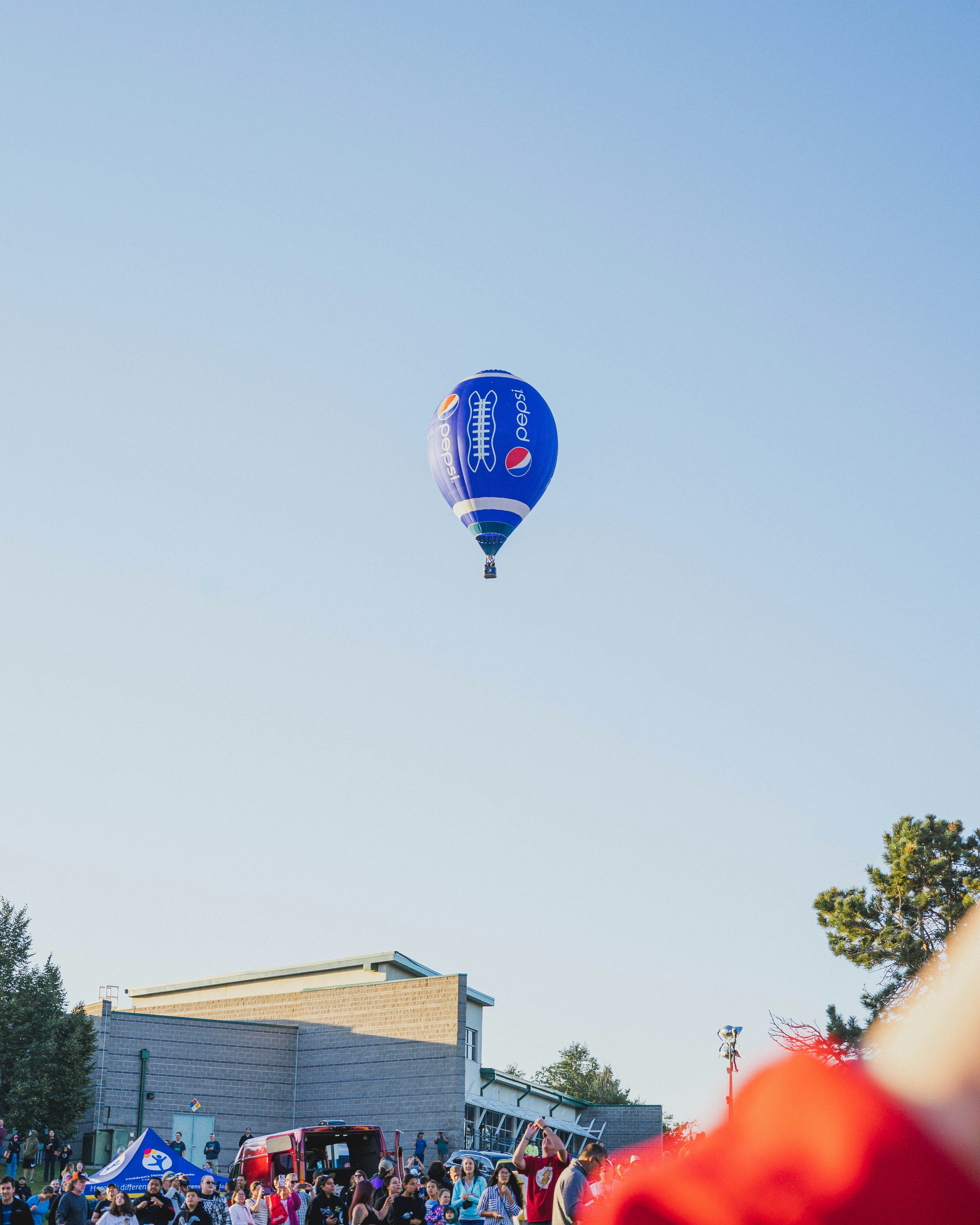Blue Pepsi Balloon Drifts Over a Sunlit Festival Grounds