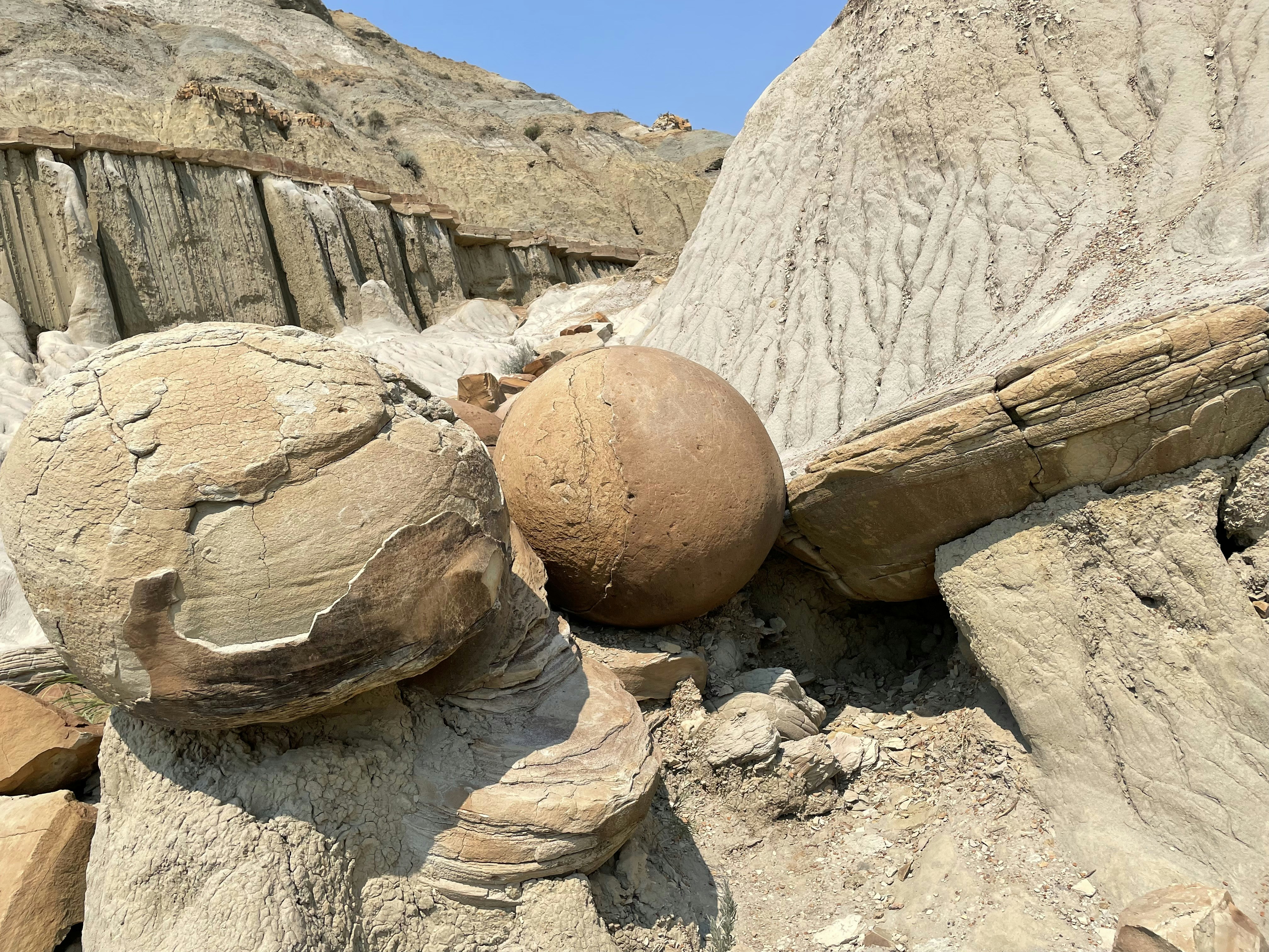 Sphere Among Weathered Cliffs: A Desert Scene of Balance and Texture