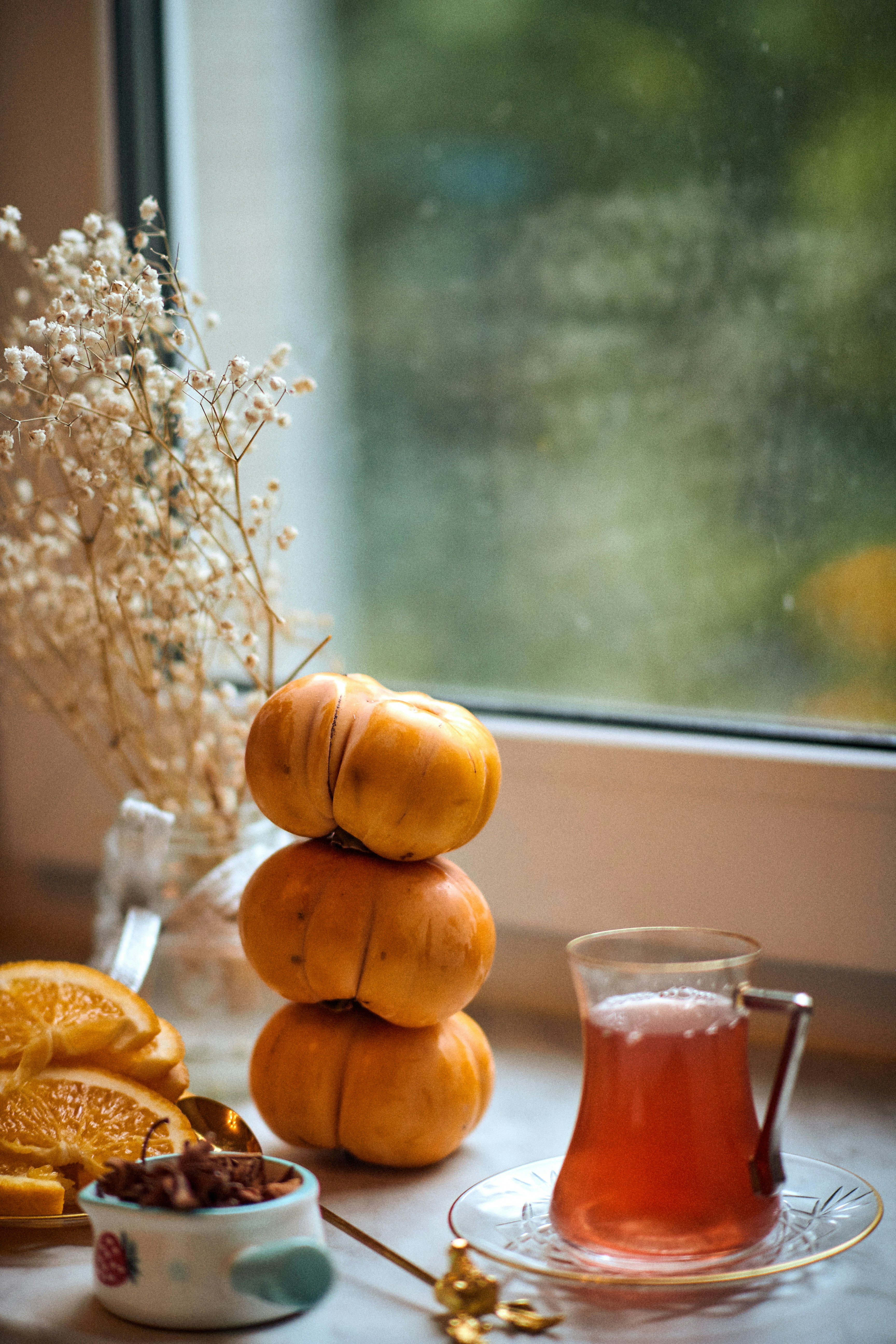 Three Tiny Pumpkins Balanced on a Sunlit Windowsill