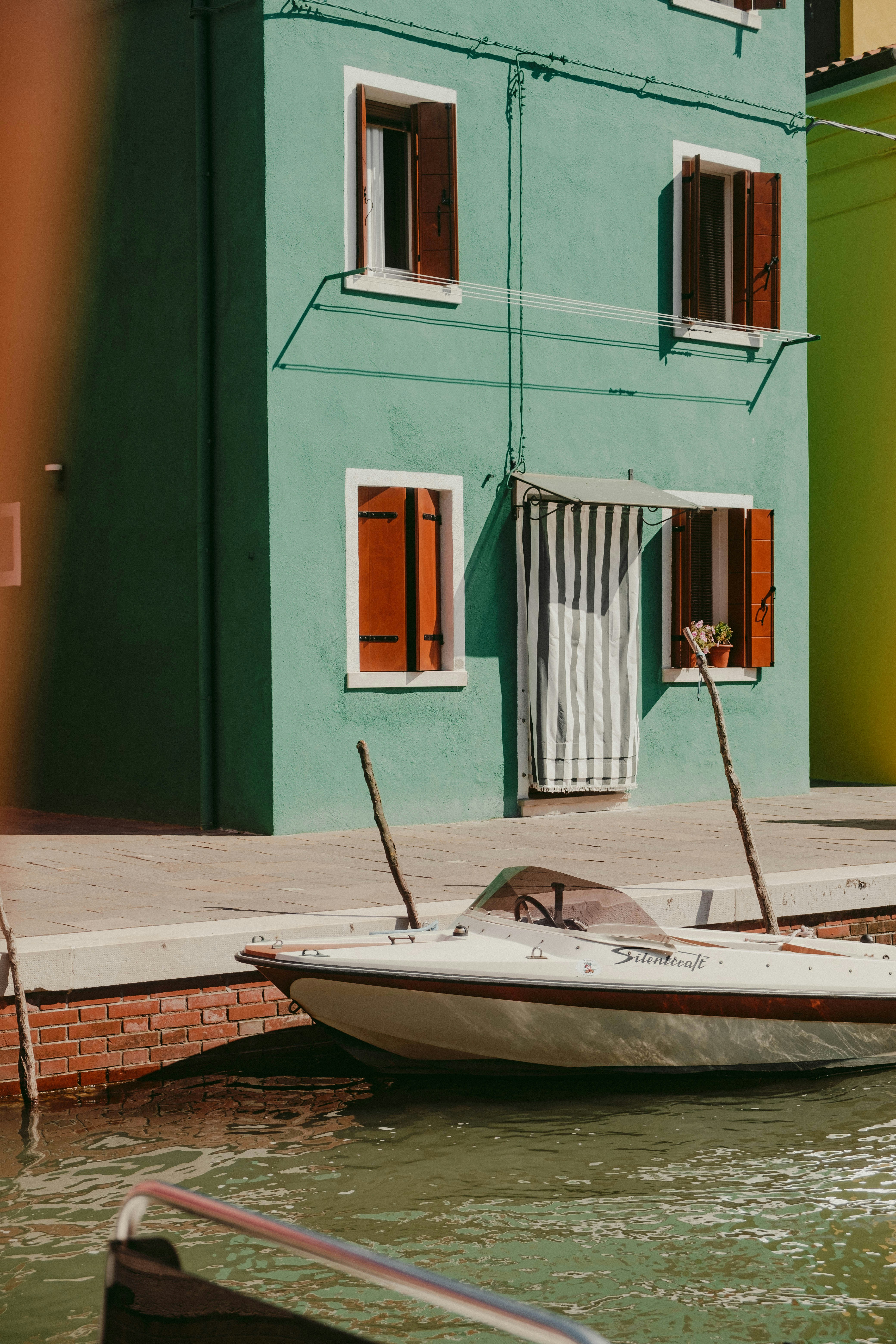 Turquoise House by the Canal with Docked Boat