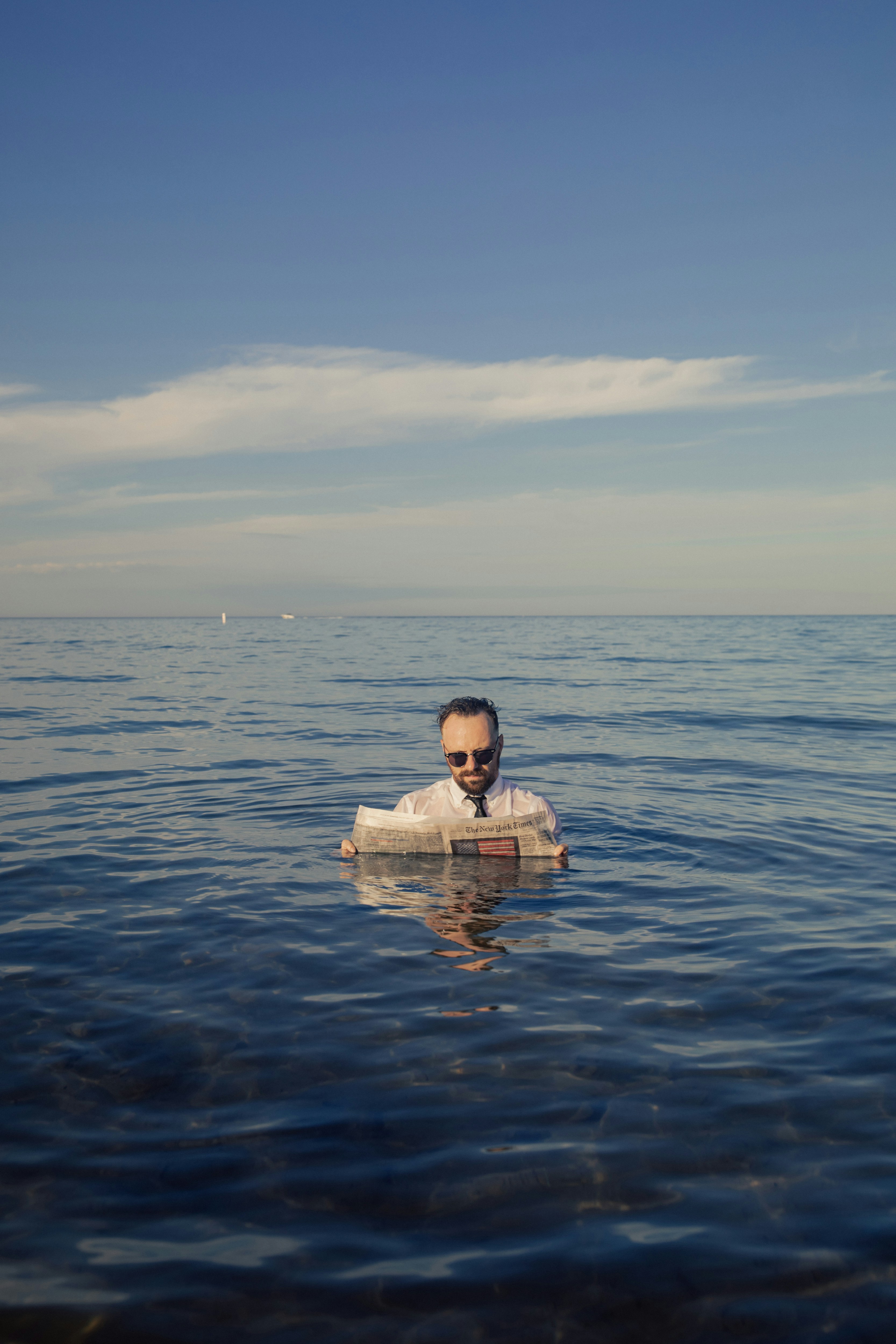 Man Reading a Newspaper While Floating in Ocean