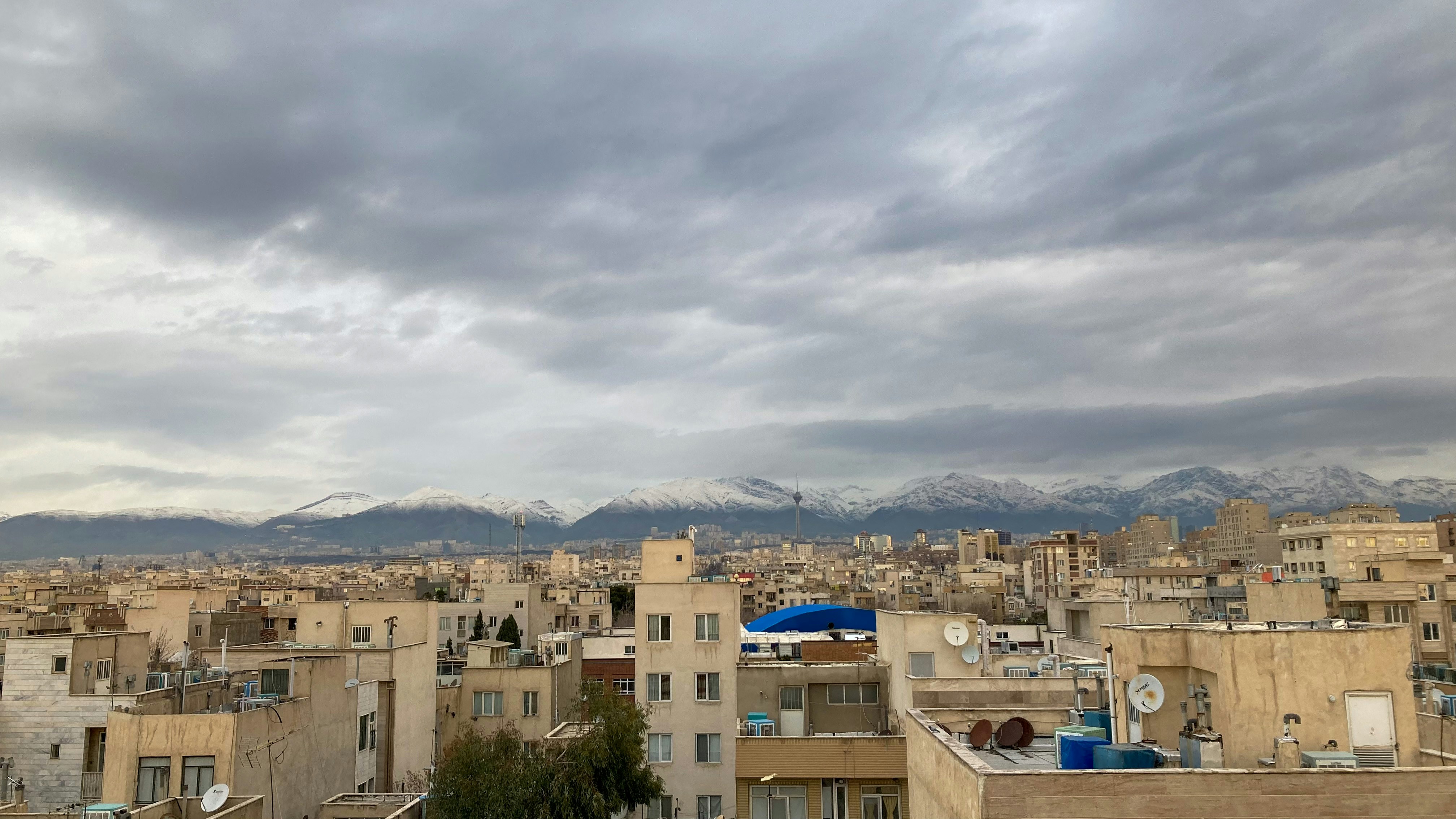 Azure Rooftop Dome Anchors a Cityscape Against Snowbound PeaksMohammad Kiaei