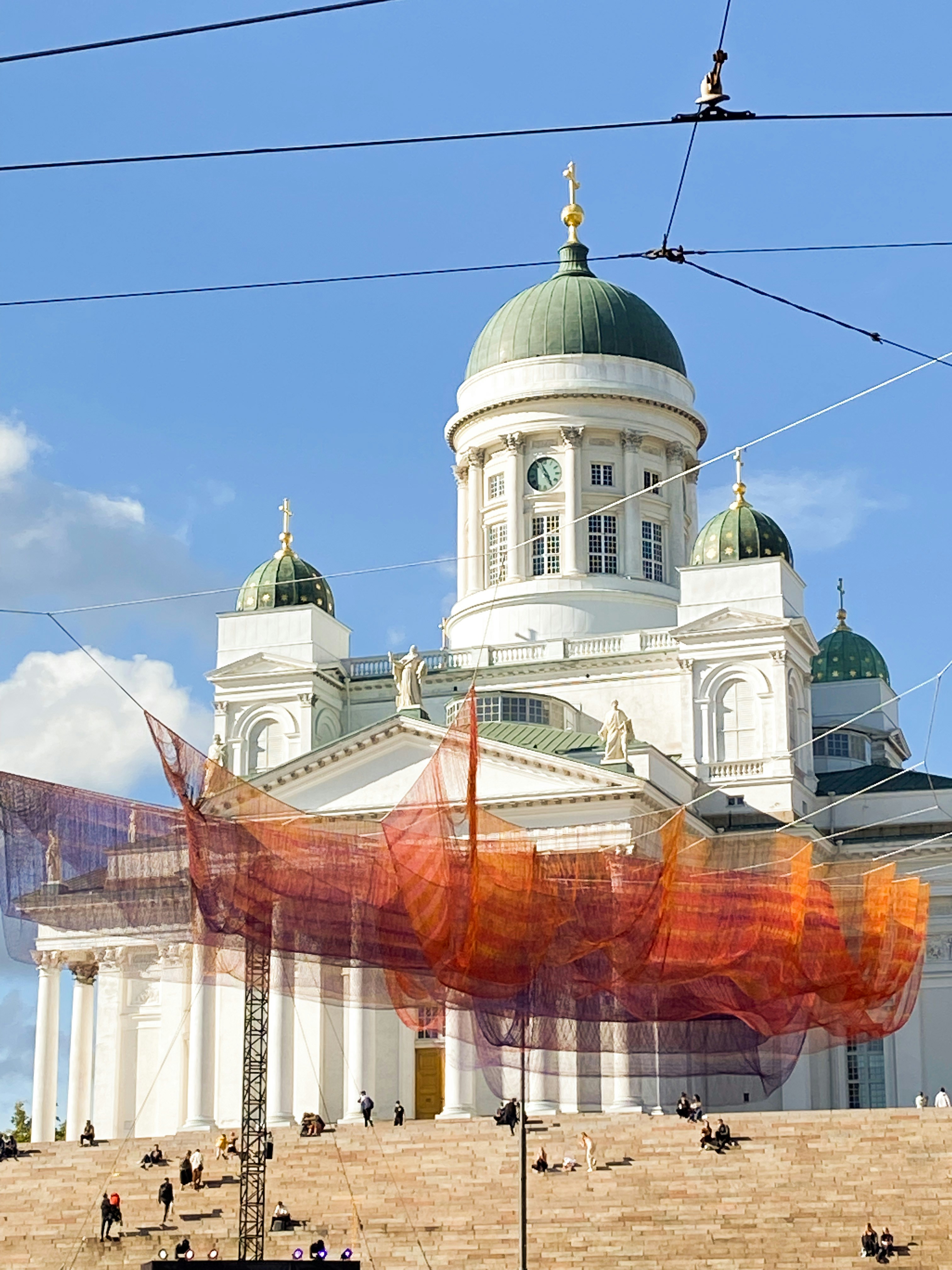 Orange Veil Draped Across a Green-Domed Cathedral on a Clear Day