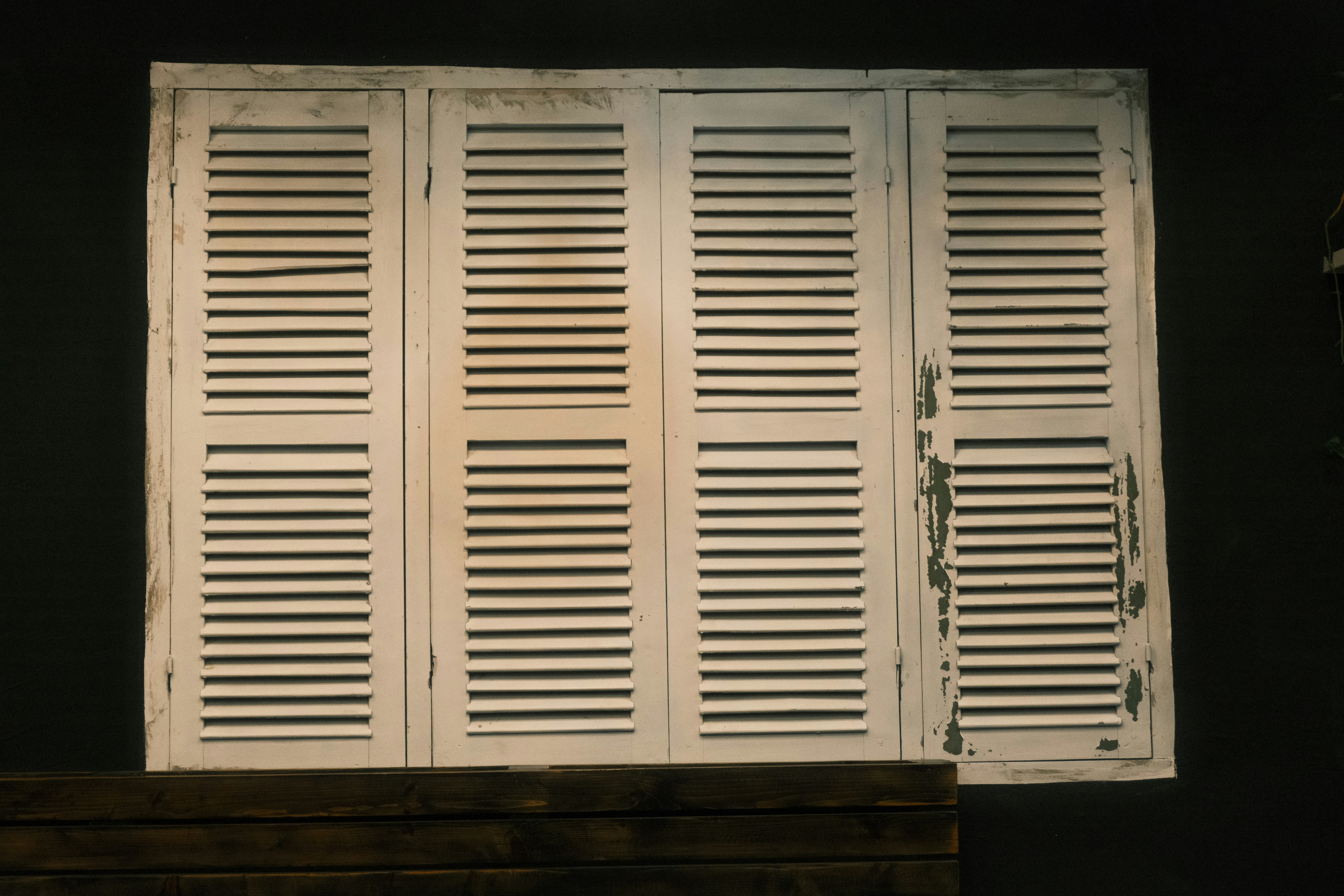 Weathered shutters under a dark beam