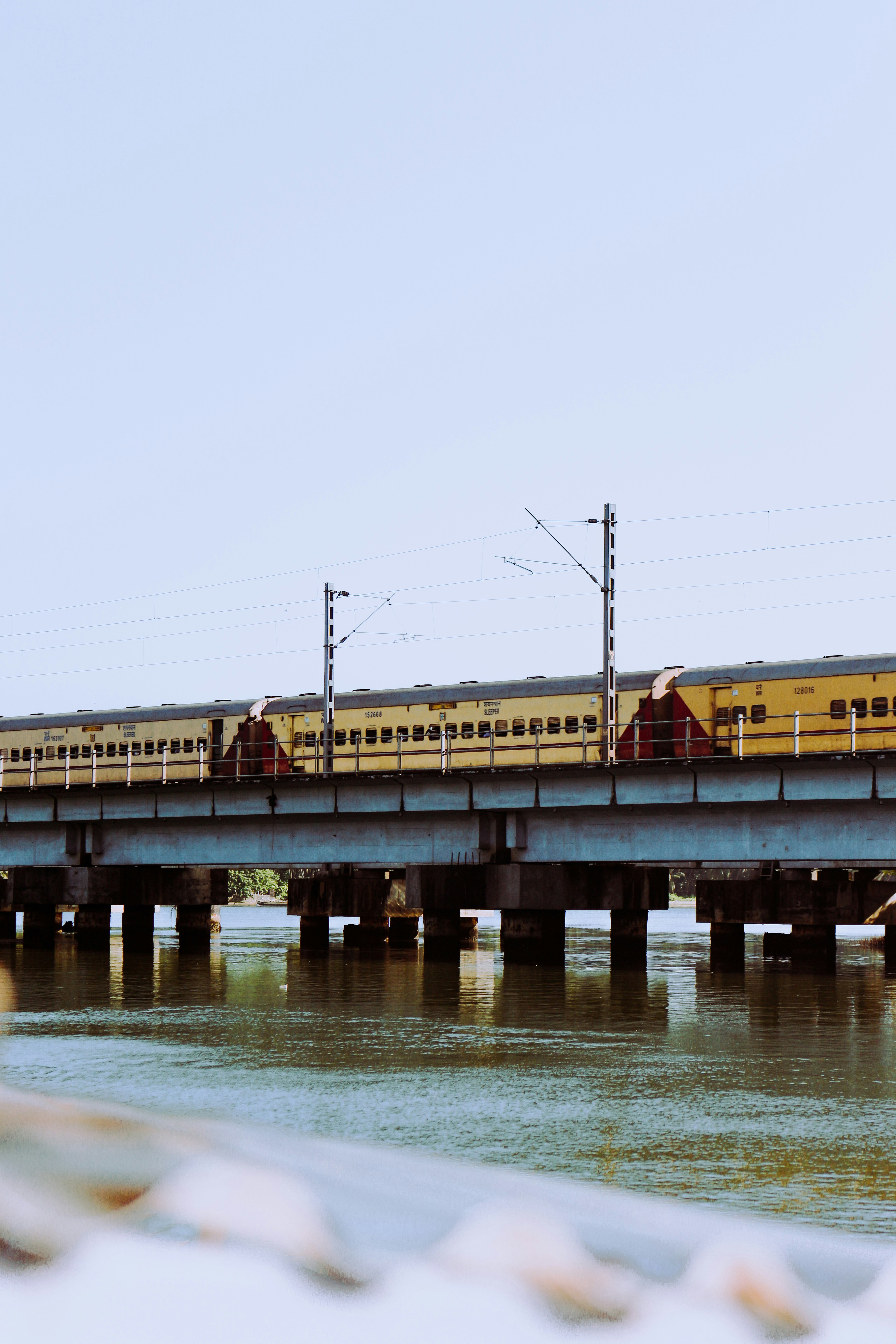 Yellow Intercity on a Quiet River Crossing