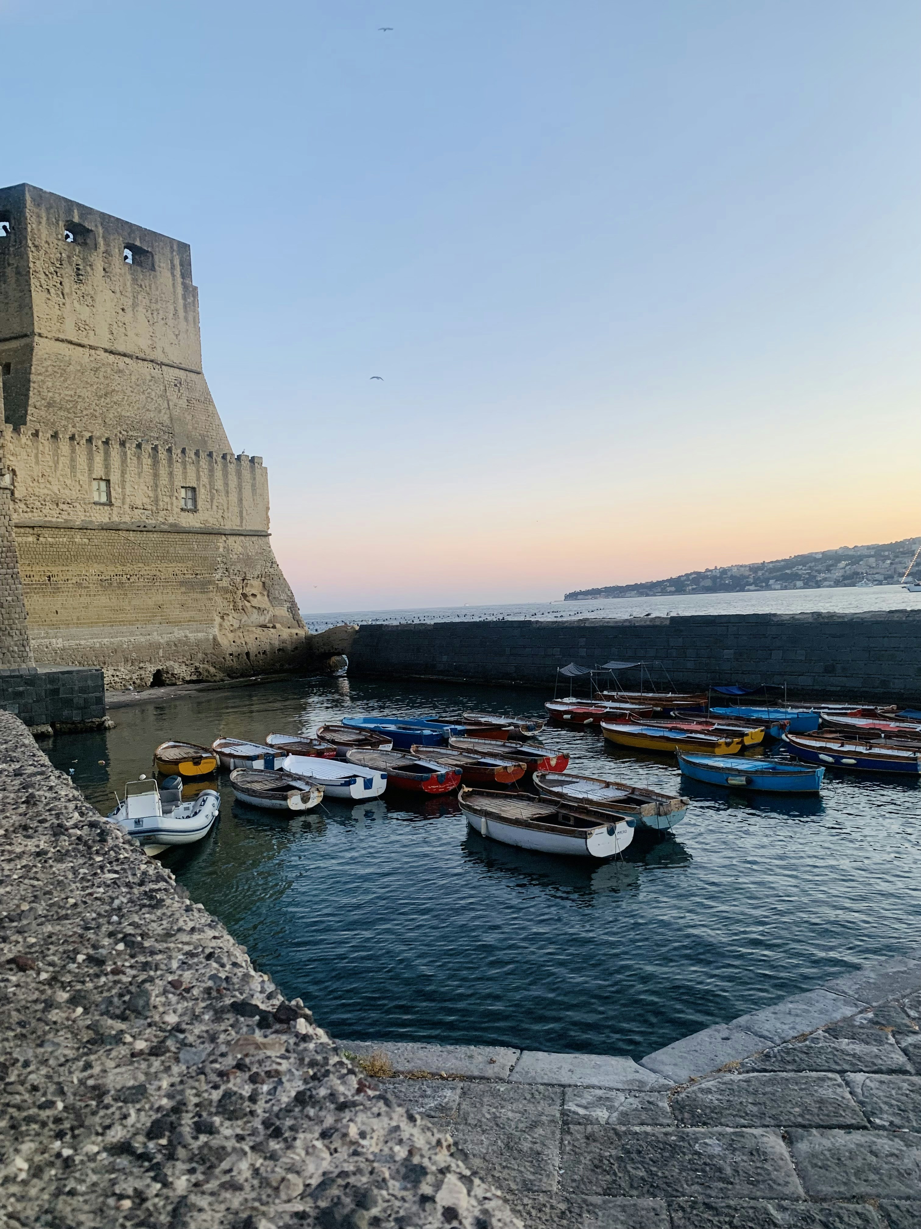 Sunset at the Citadel Harbor: Boats Nestle Against Weathered Walls