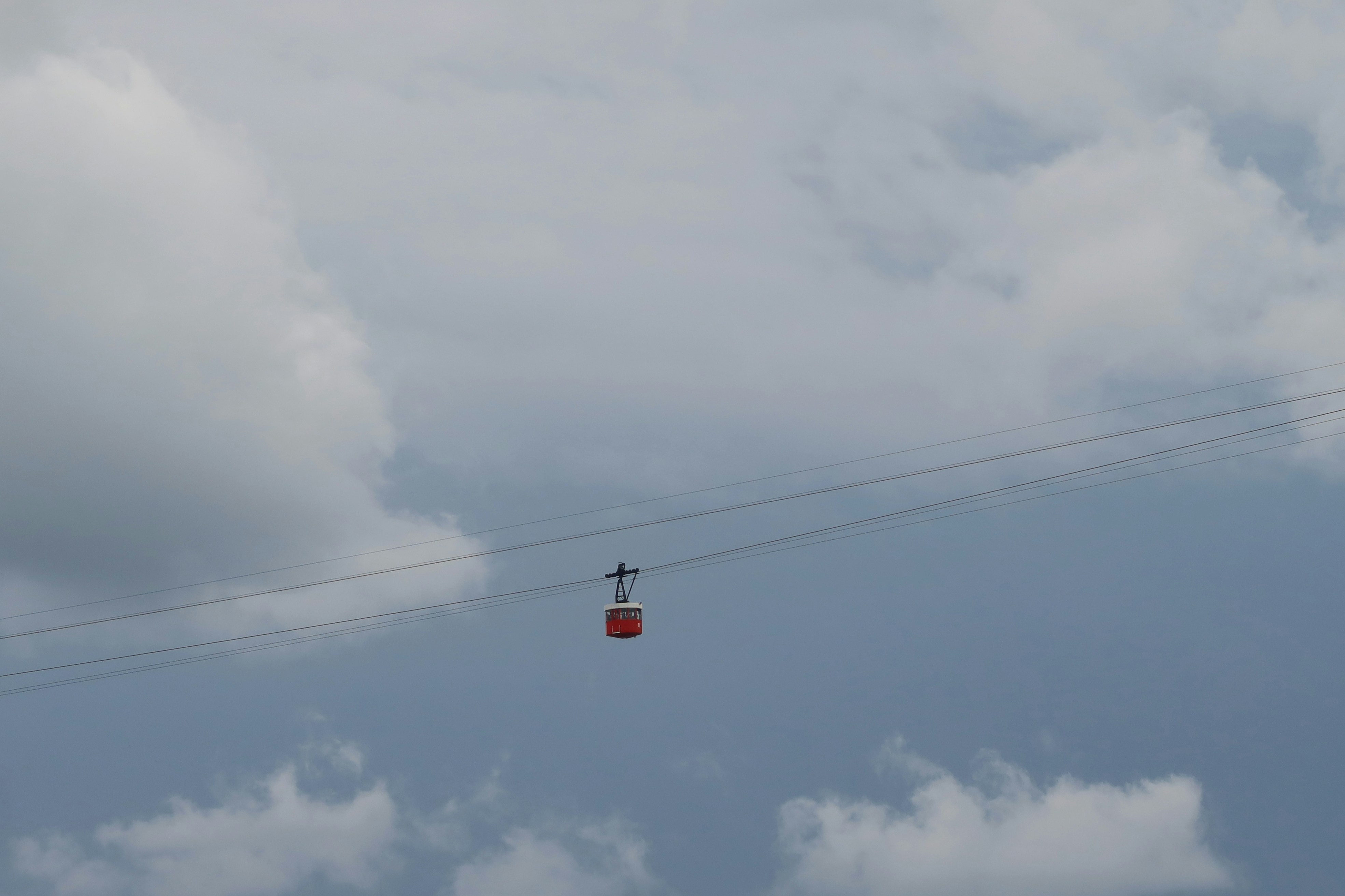 Red Gondola Crossing the Quiet Blue Expanse