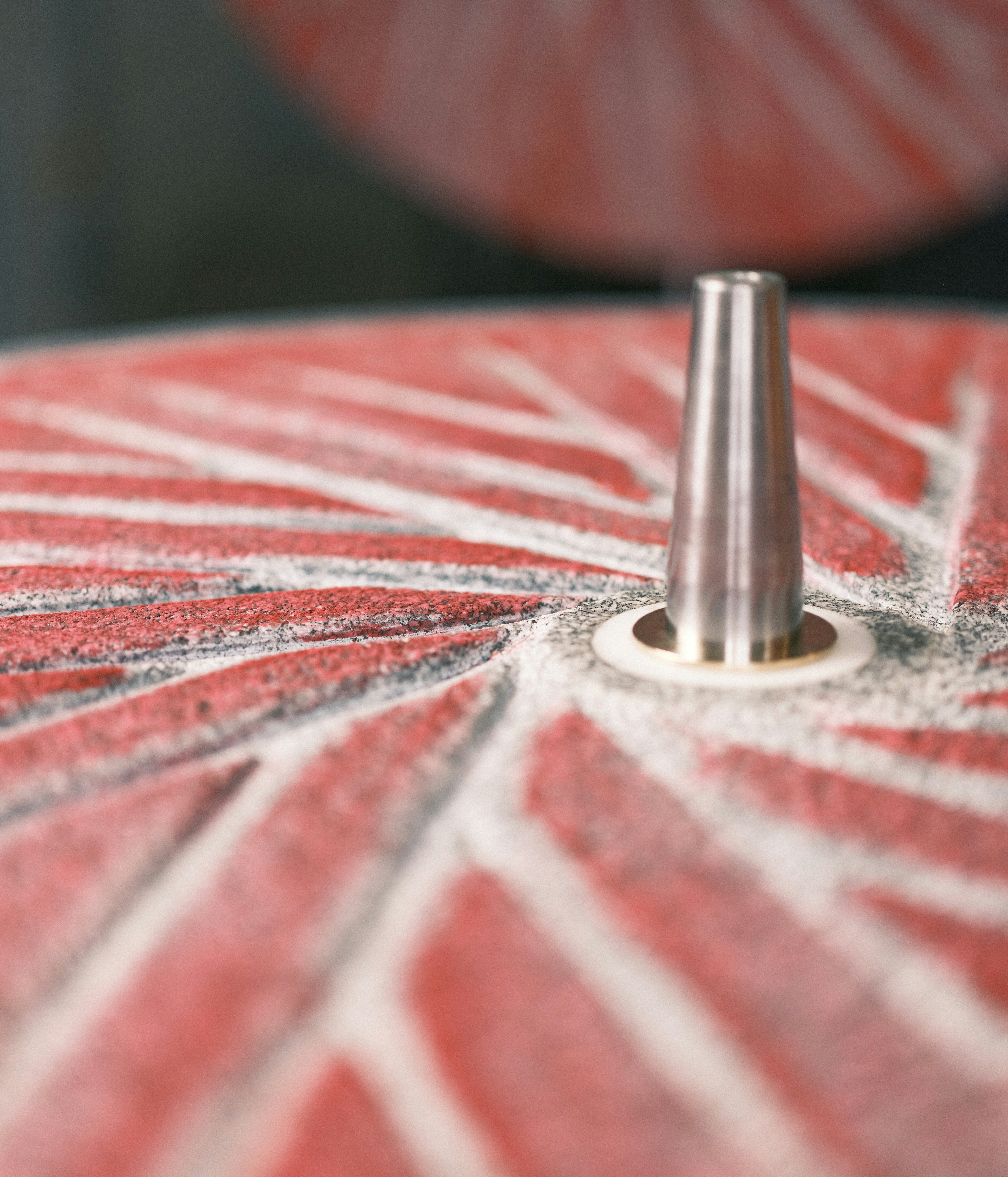 a close-up of a needle on a red and white striped cloth