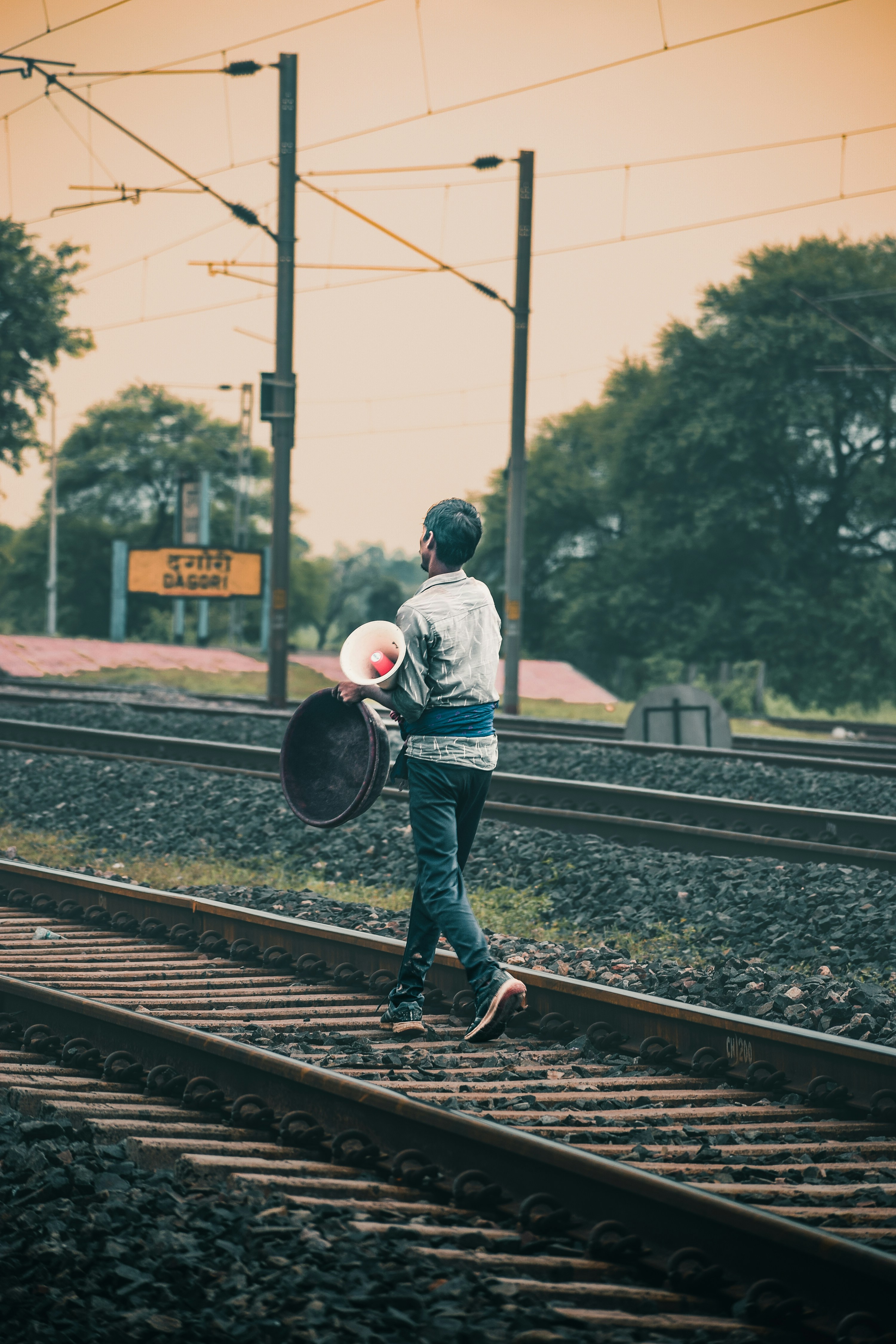 A man holding a tennis ball on a train track photo – Free Railway Image ...