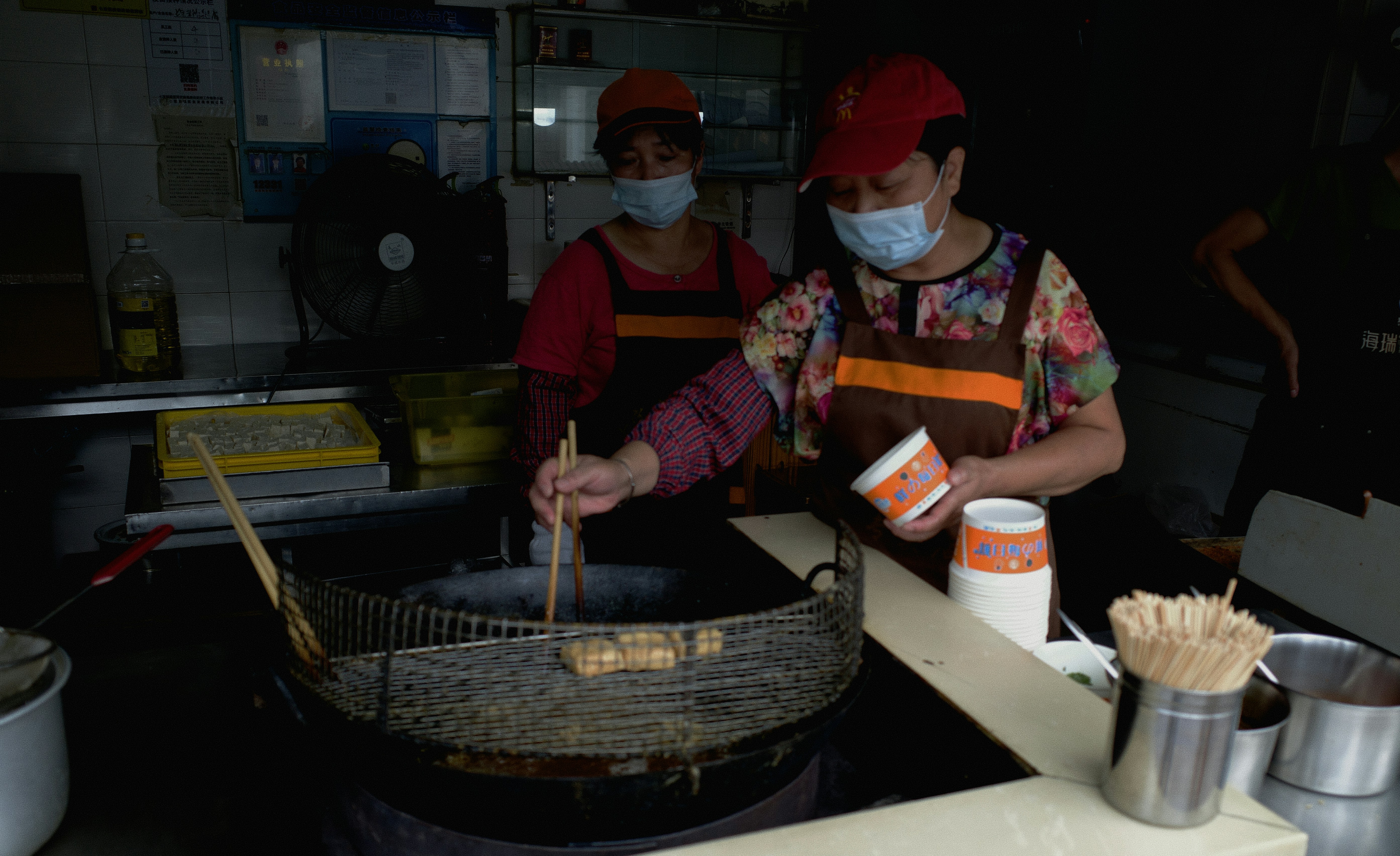 A couple of women wearing masks and cooking in a kitchen photo – Free ...