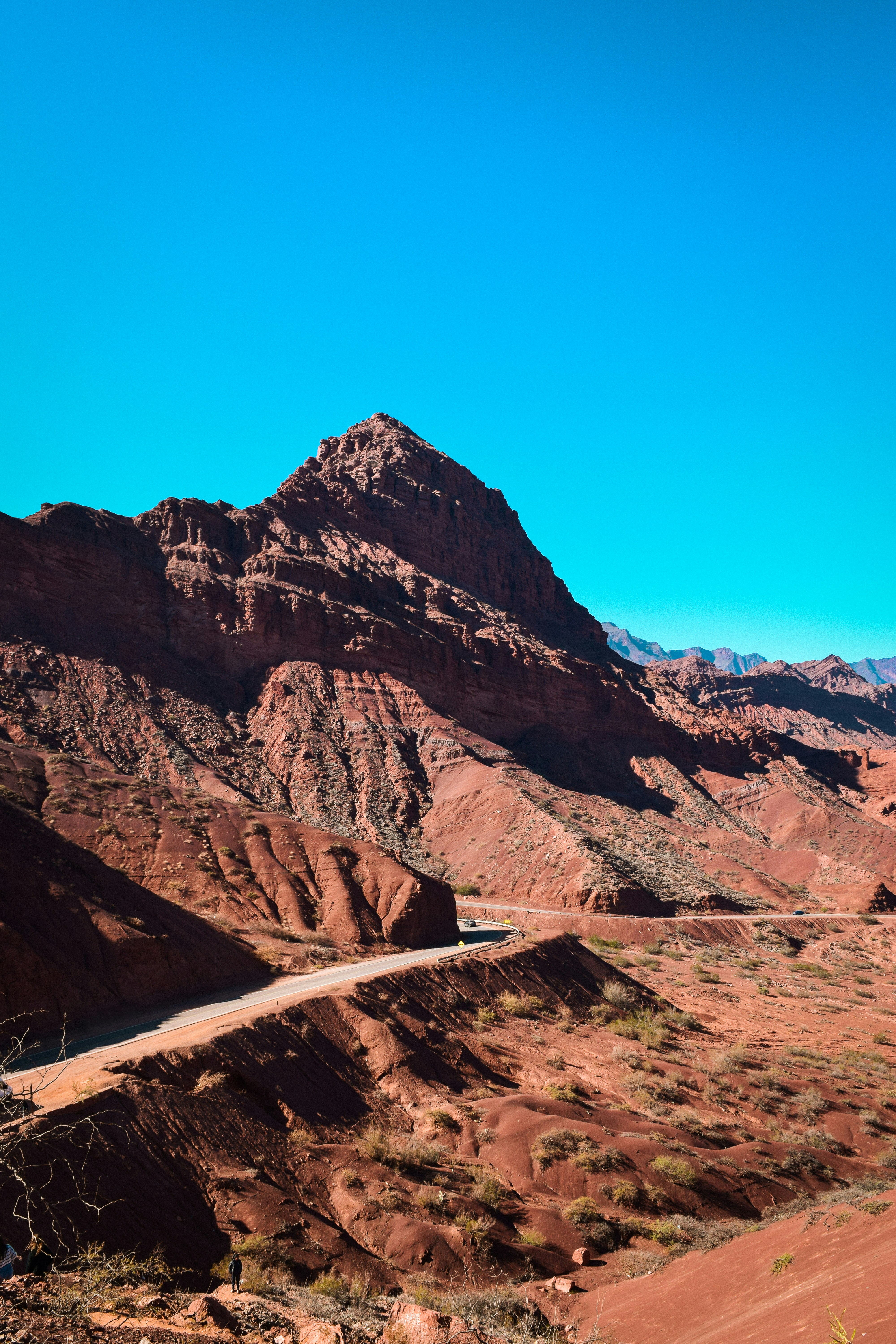 Crimson Cliffs and a Winding Road Under an Endless Blue