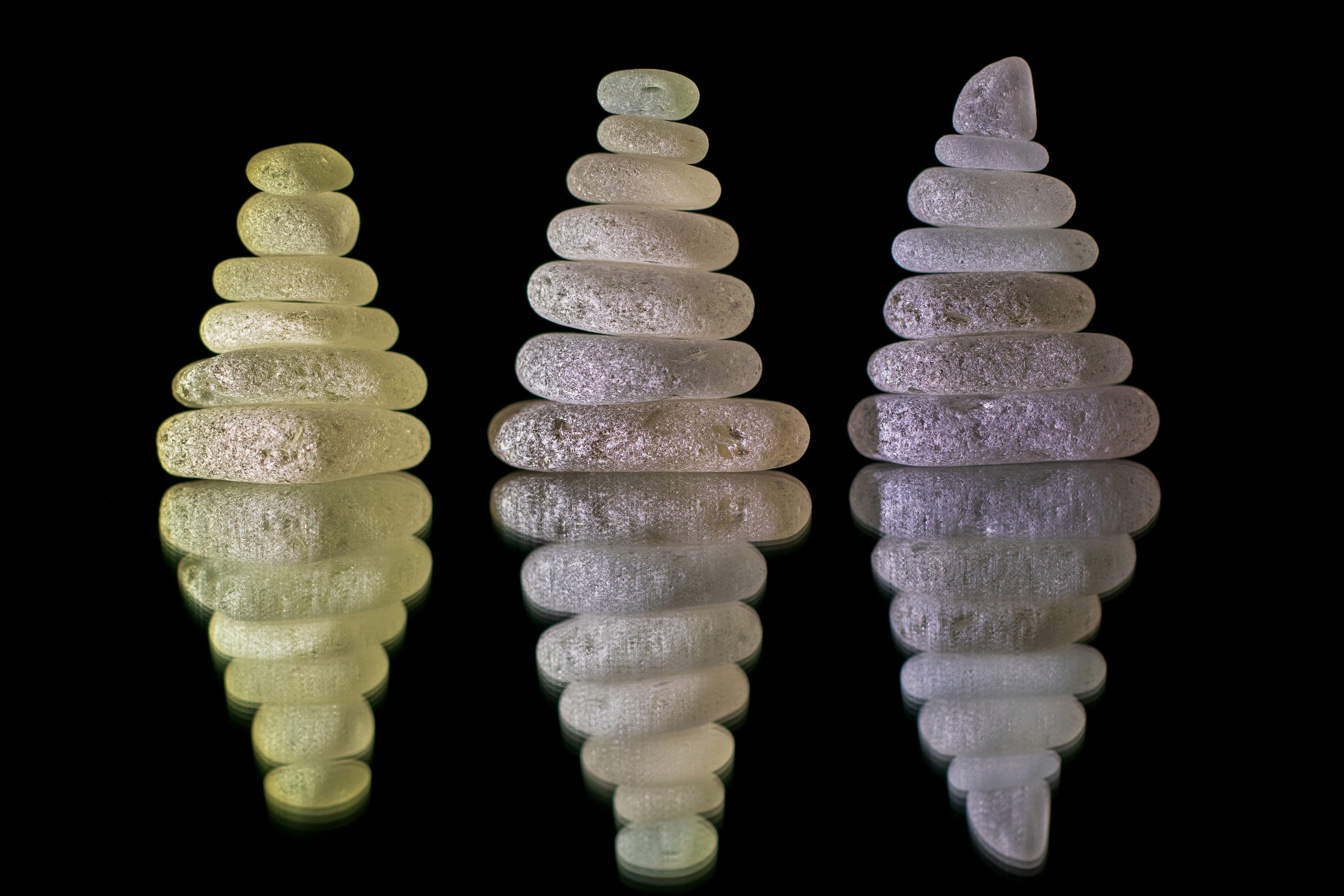 Triad of Pebble Totems Bathed in Chromatic Light