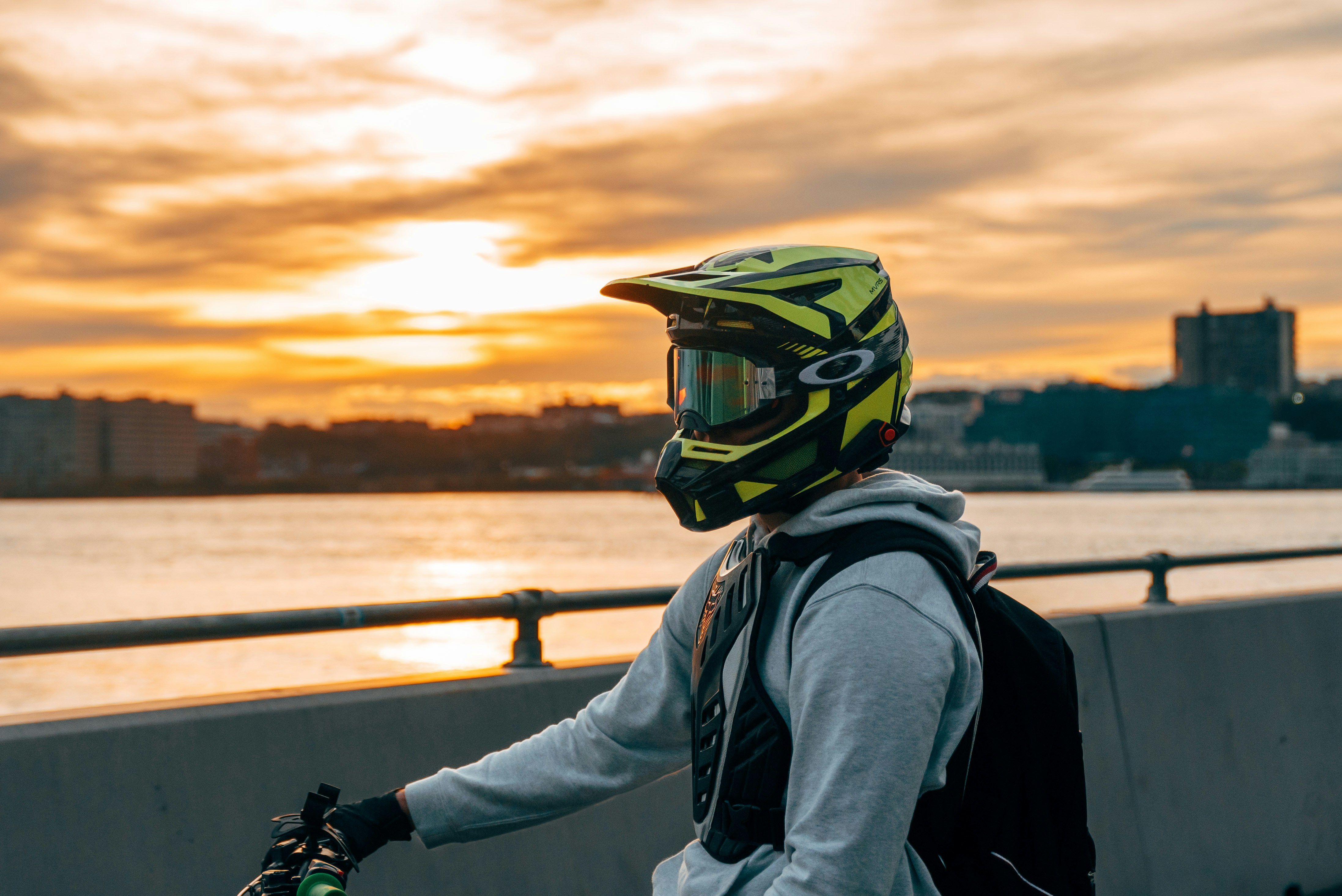 Lime-helmeted Rider on a Waterfront Bridge at Golden Hour