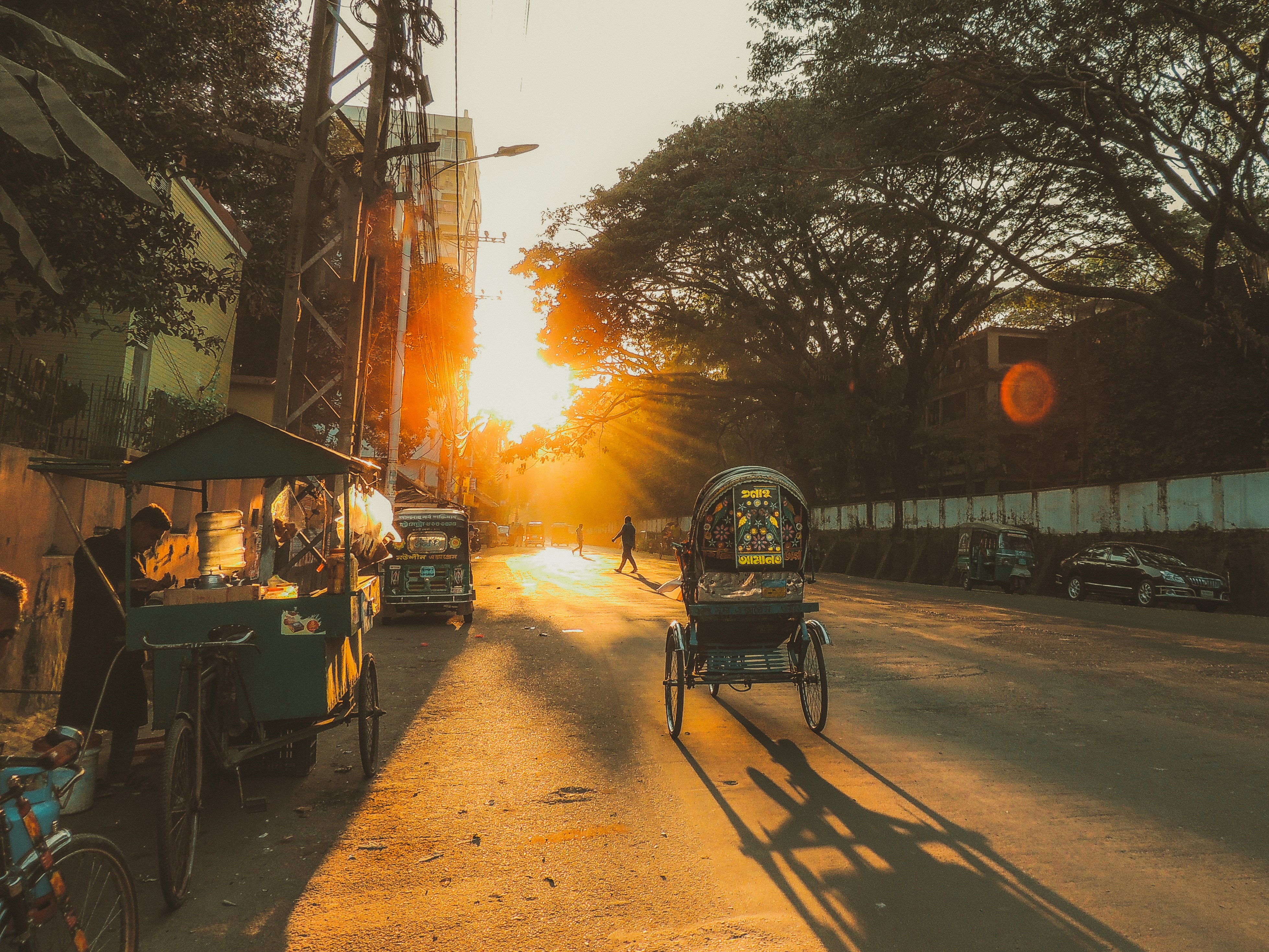 Golden Hour Confluence: Market Stalls, Rickshaws, and a Distant Runner