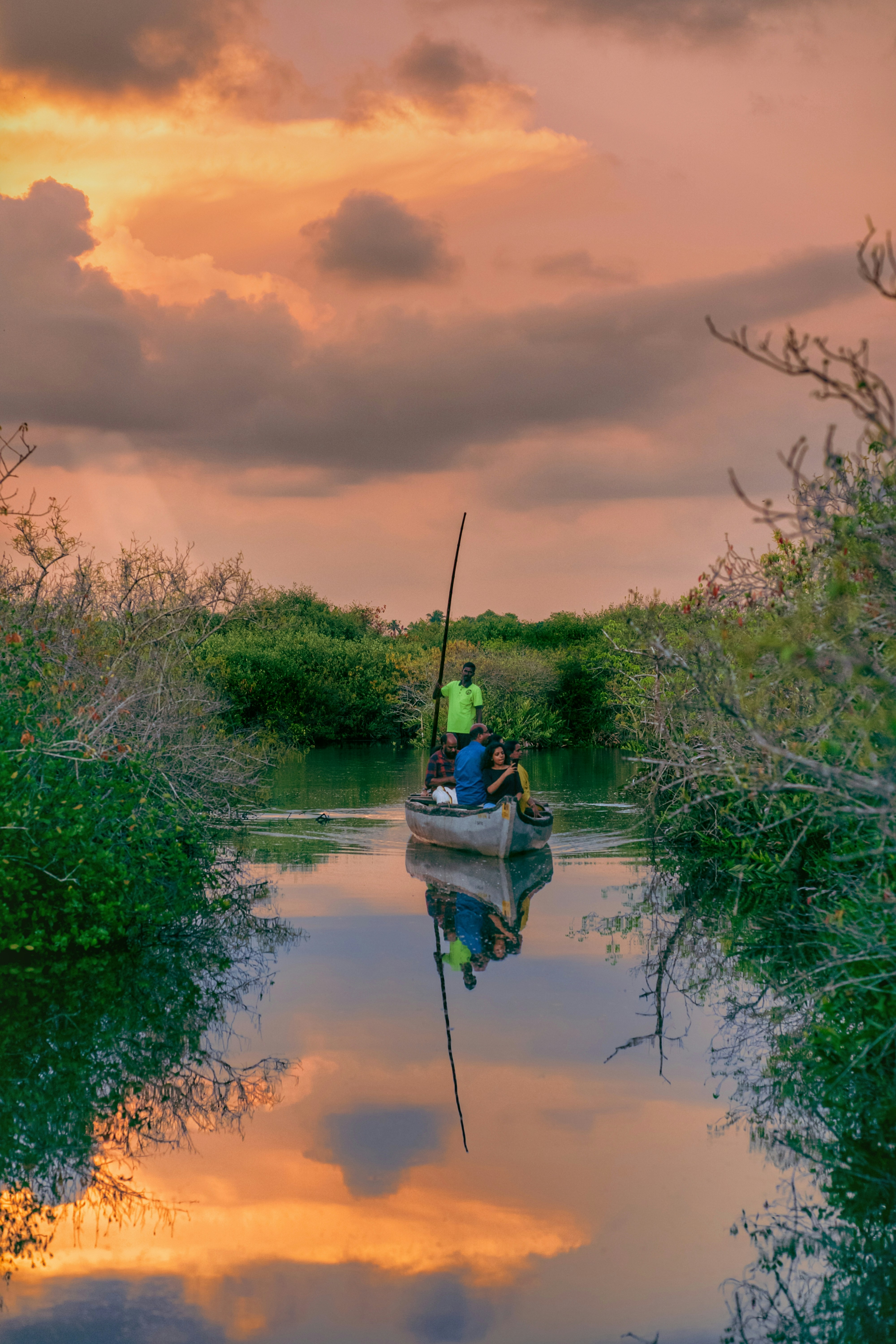 People travelling in wooden boat over the Kerala back water during sunset