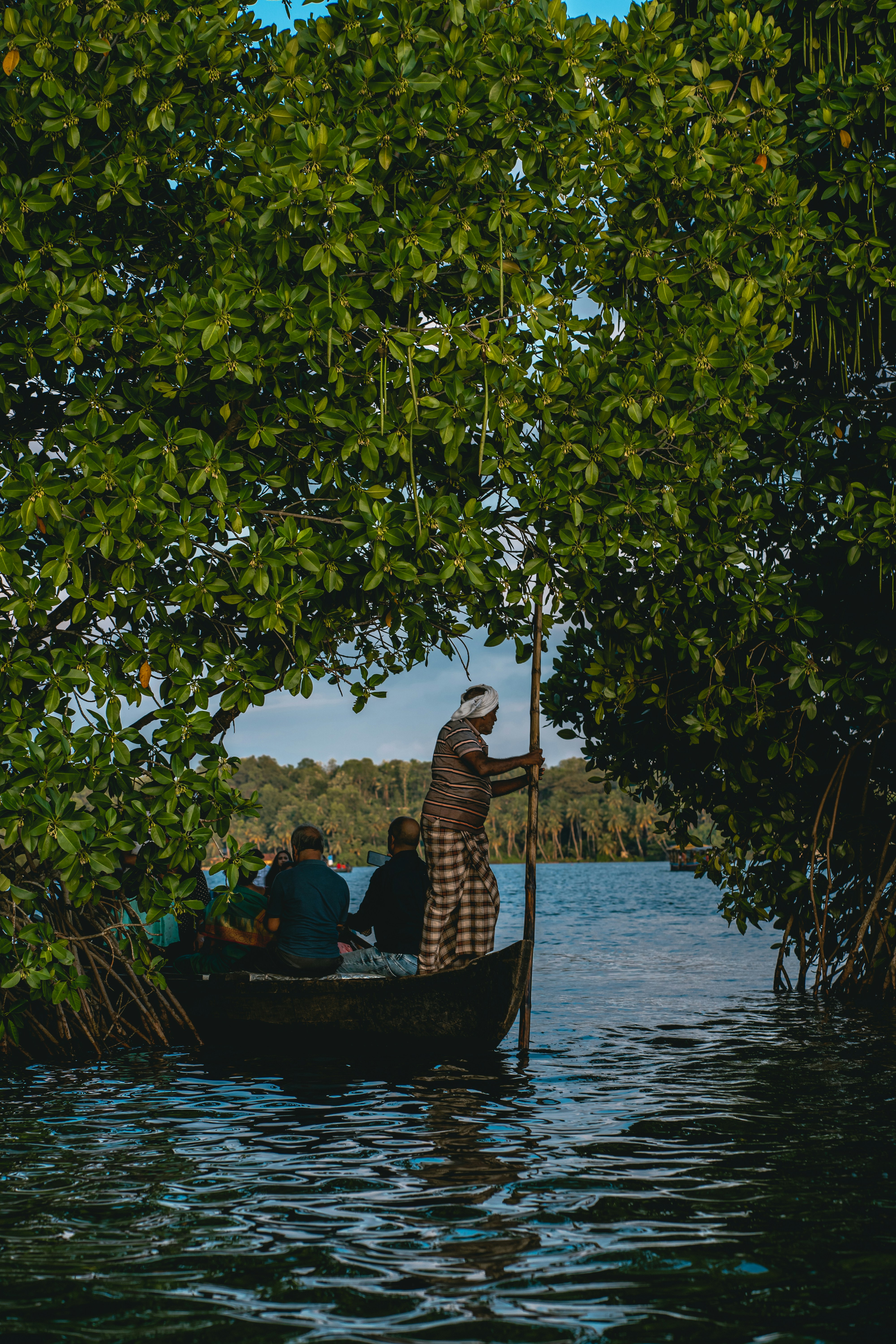People travel on wooden boat in Kerala backwater during sunset
