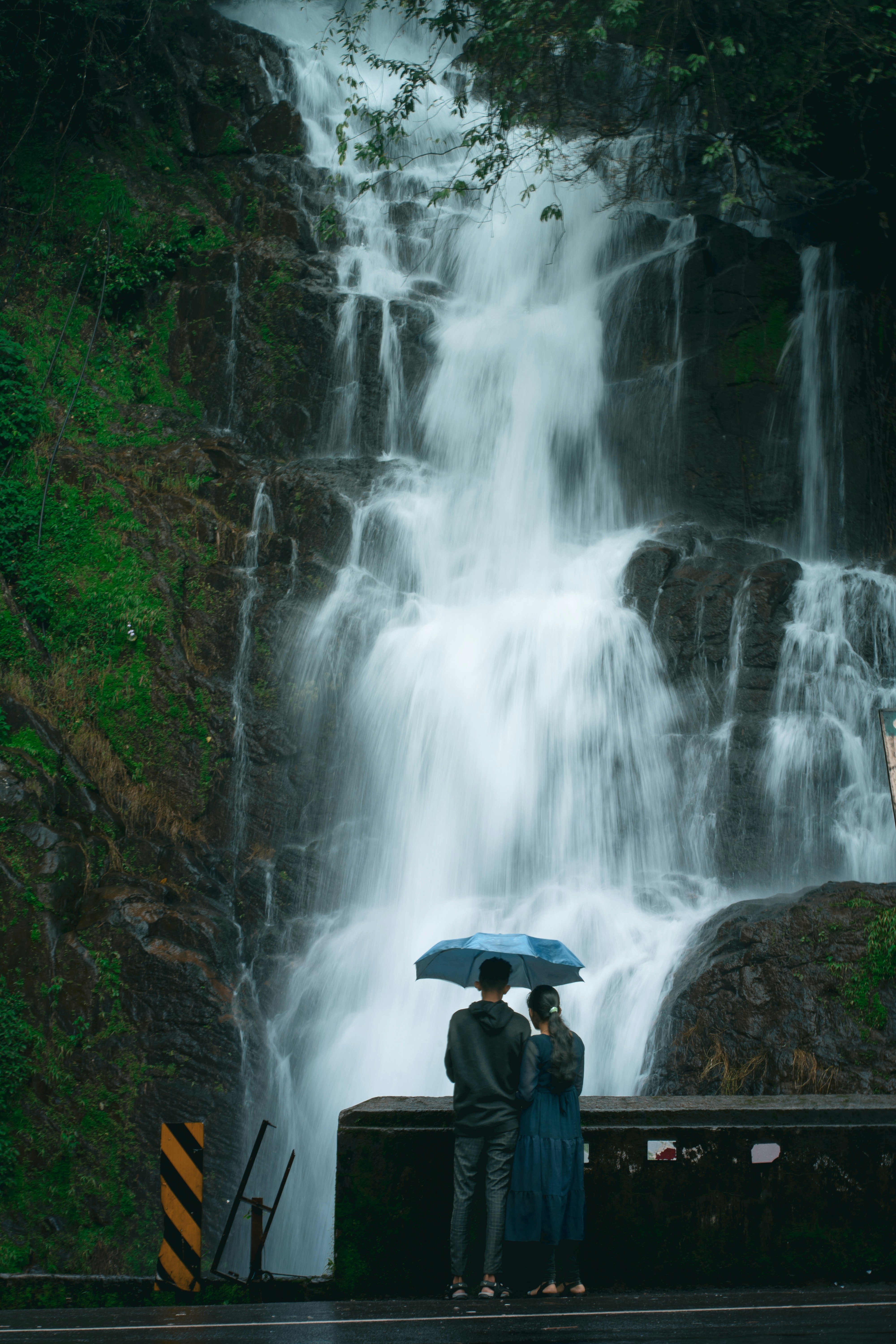 Young Indian couple in front of the waterfall at Idukki Kerala long exposure
