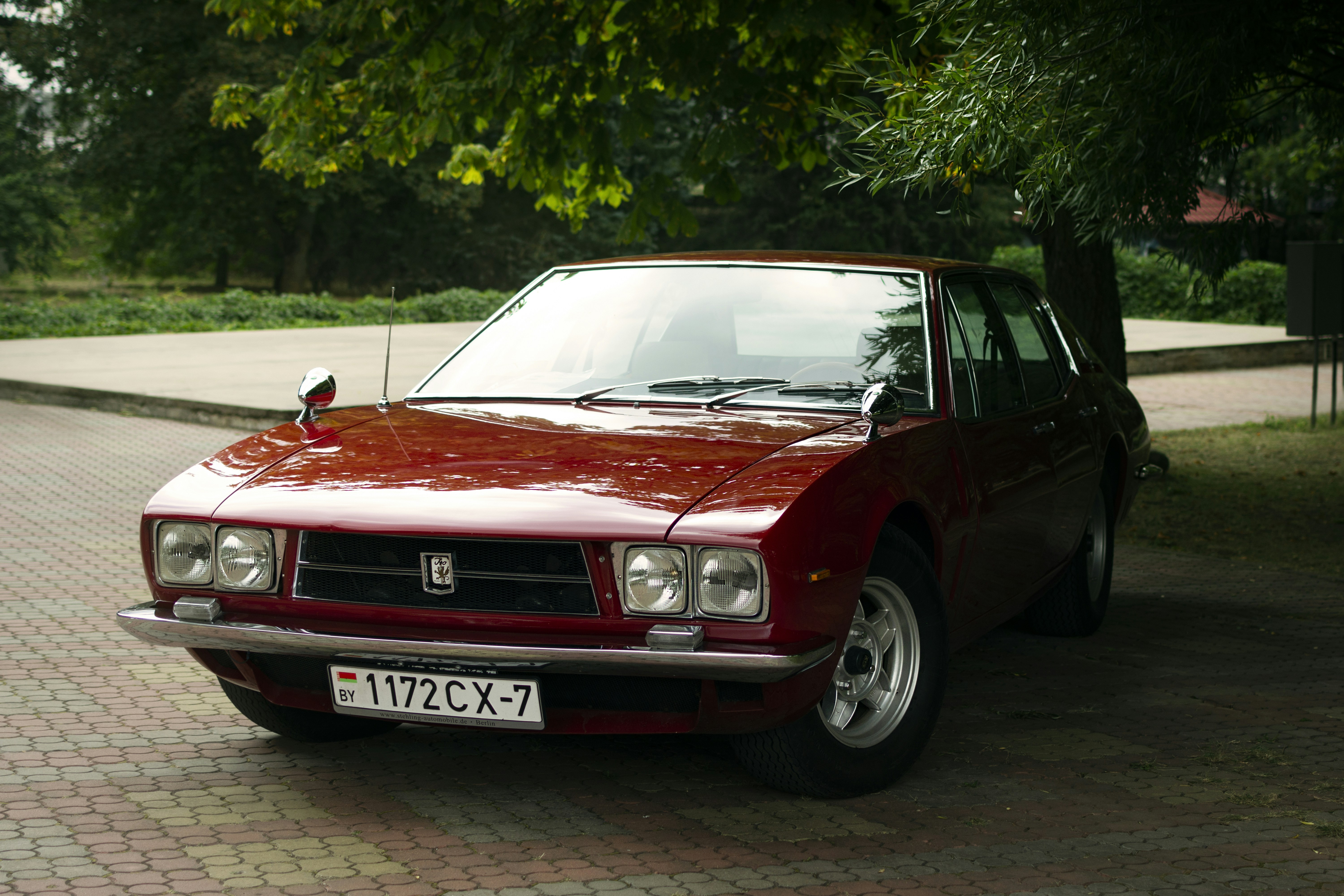 A red car parked on a brick road photo – Free S4 Image on Unsplash