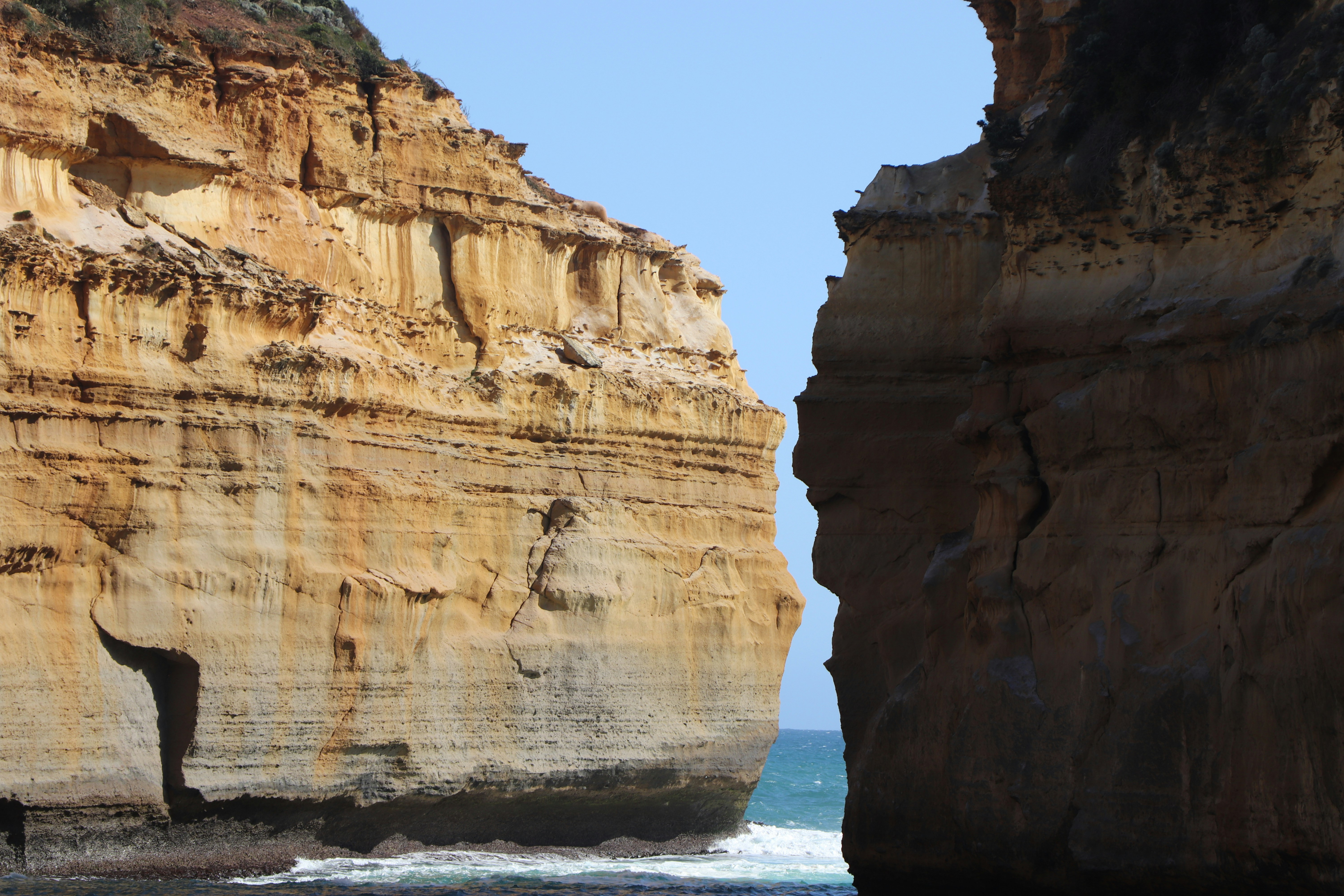A cliff side with a body of water below photo – Free Great ocean road ...