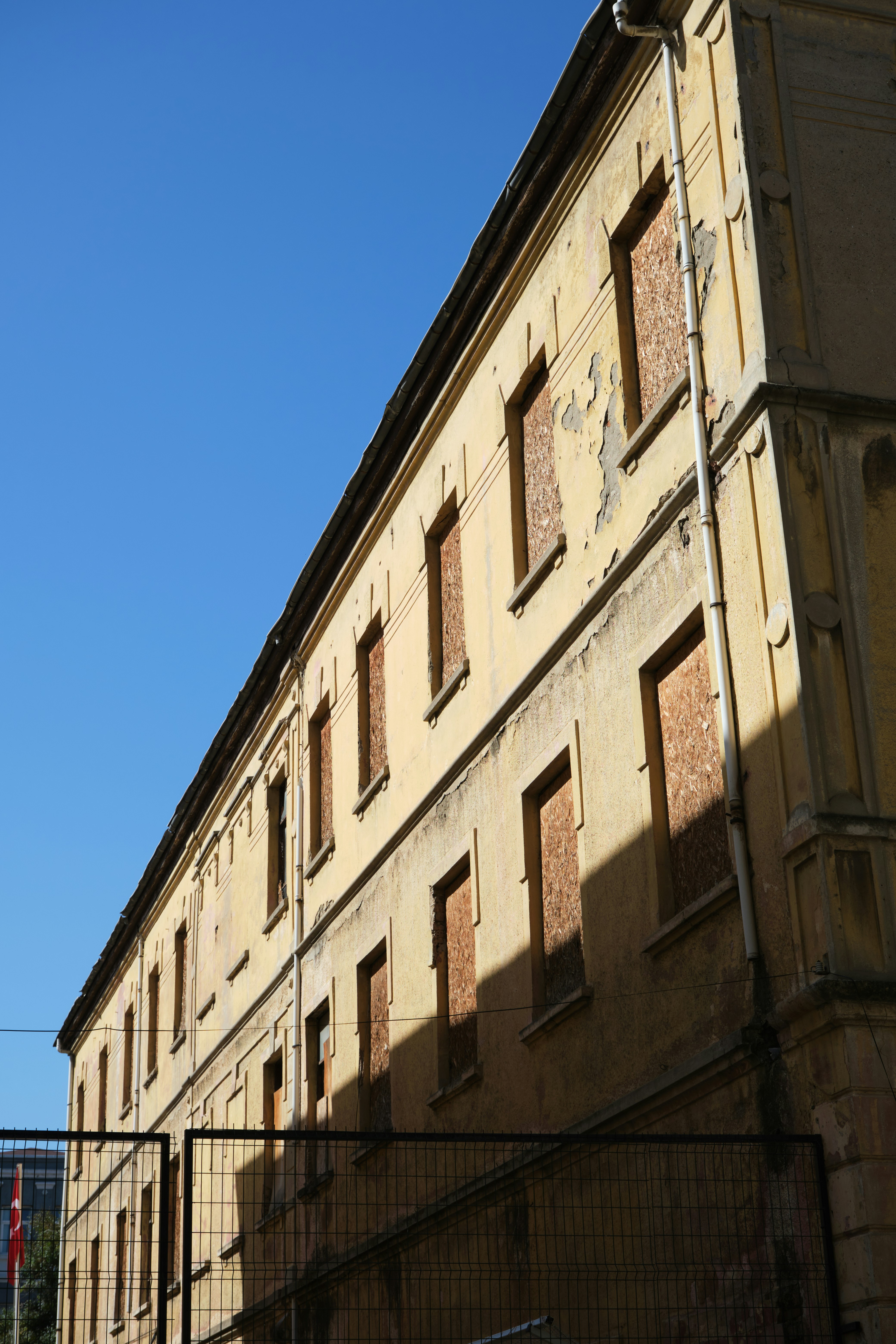An old building used as school in the past | a building with a fence