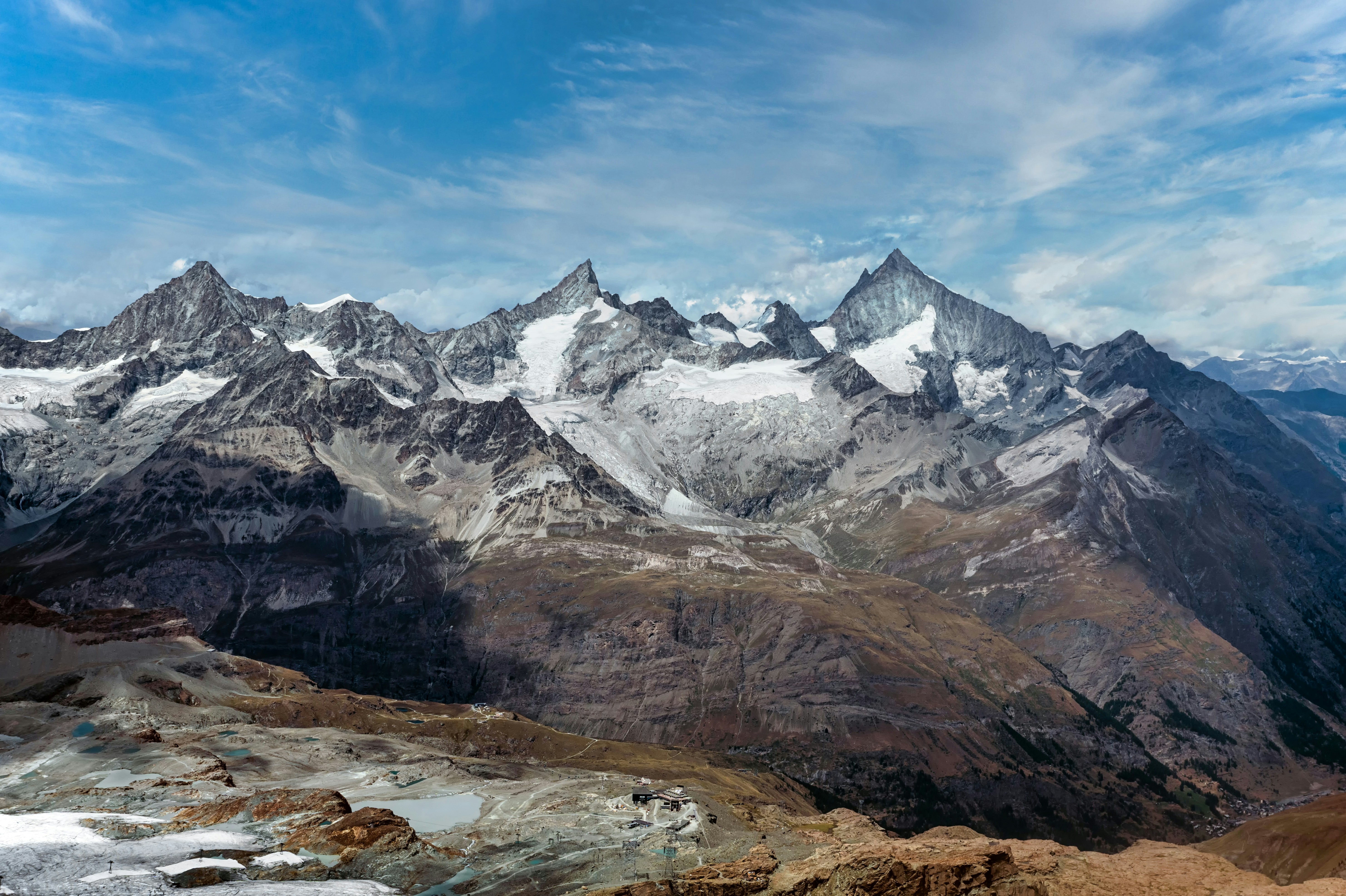 Snow-capped mountains under a vibrant blue sky in the Swiss Alps.