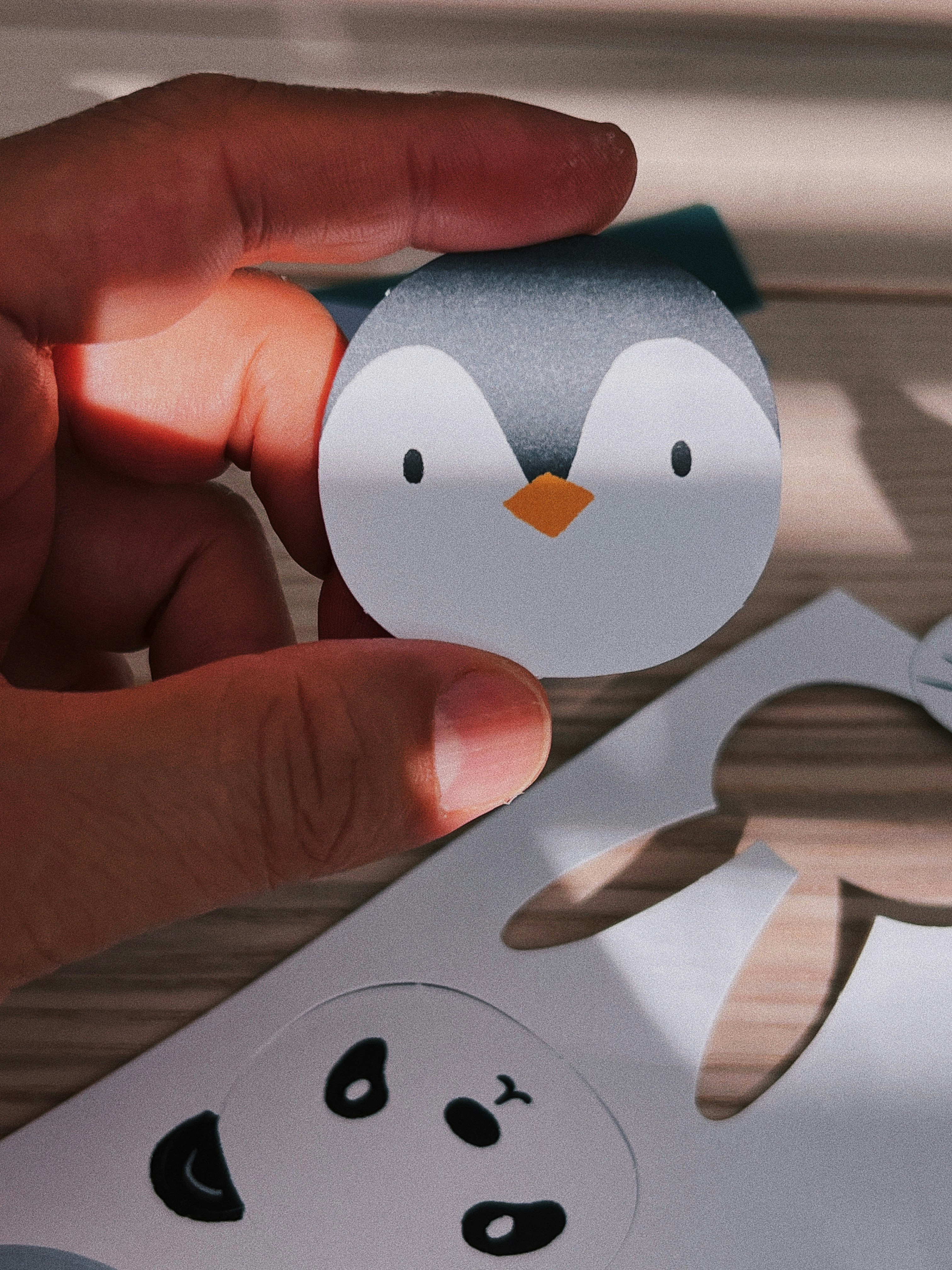 Close-up Penguin Card Cutout Held in Hand