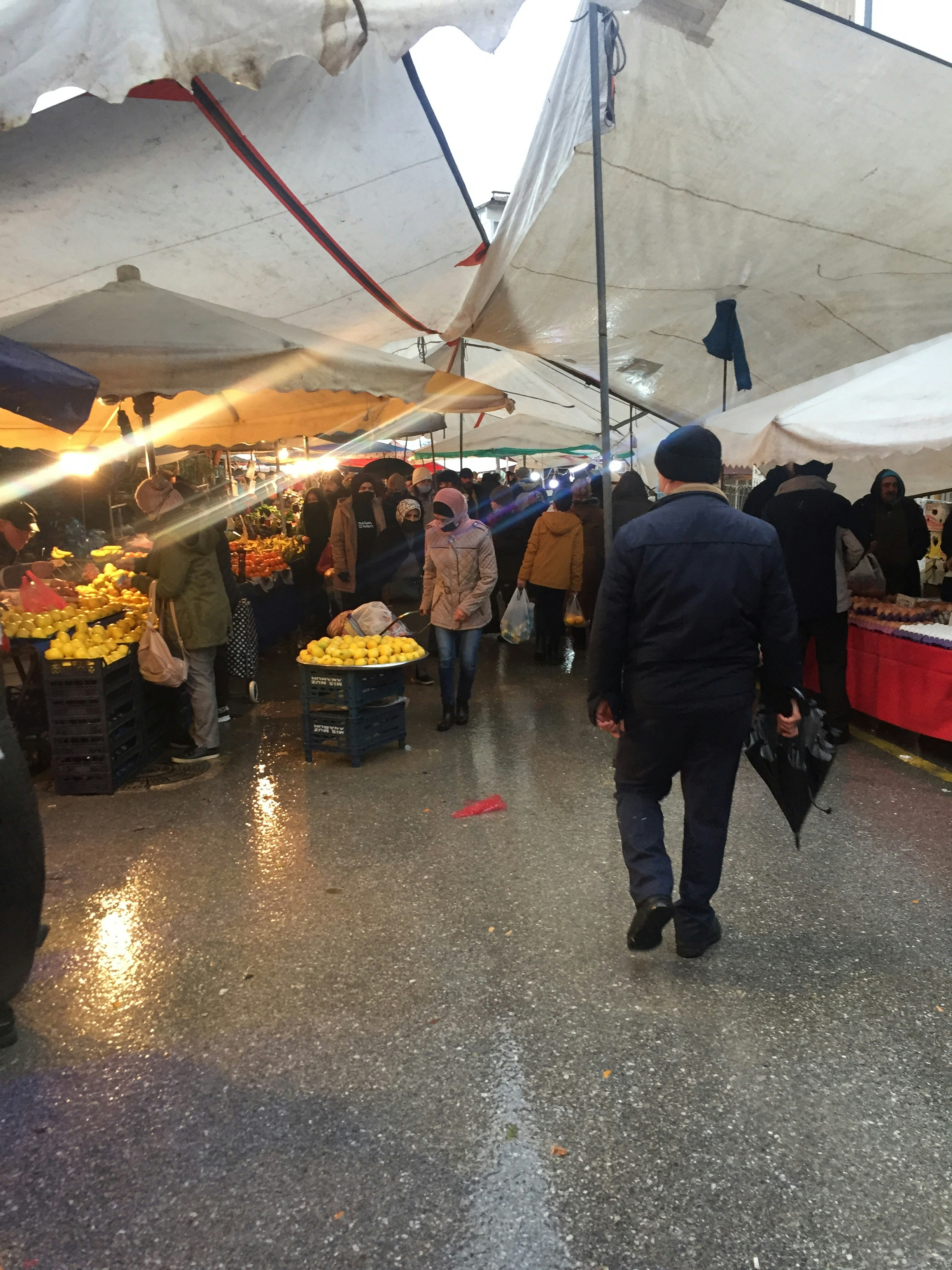 Vibrant Market Life Under Rainy Canopies
