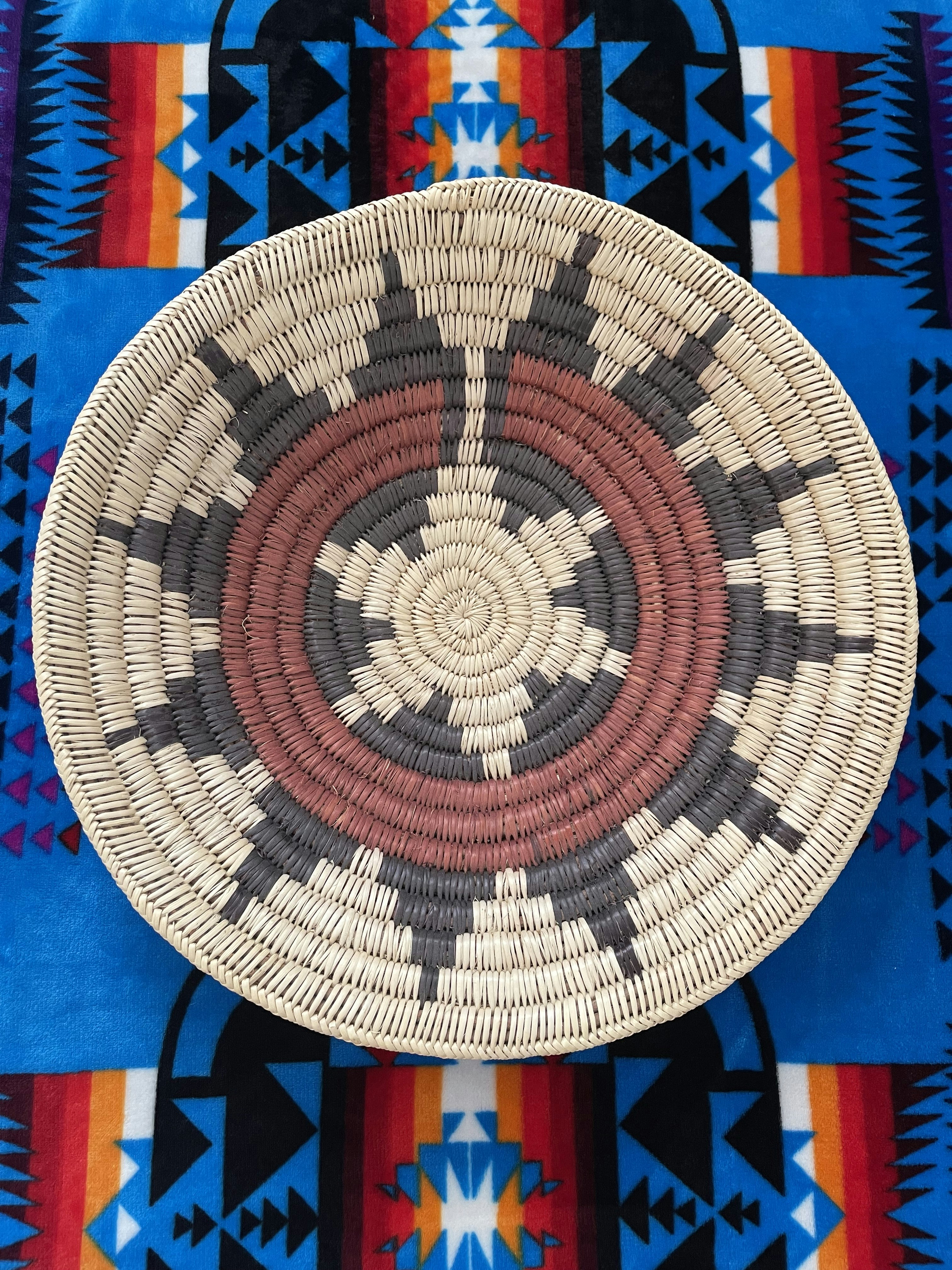 Concentric Woven Mandala on a Blue Geometric Tapestry