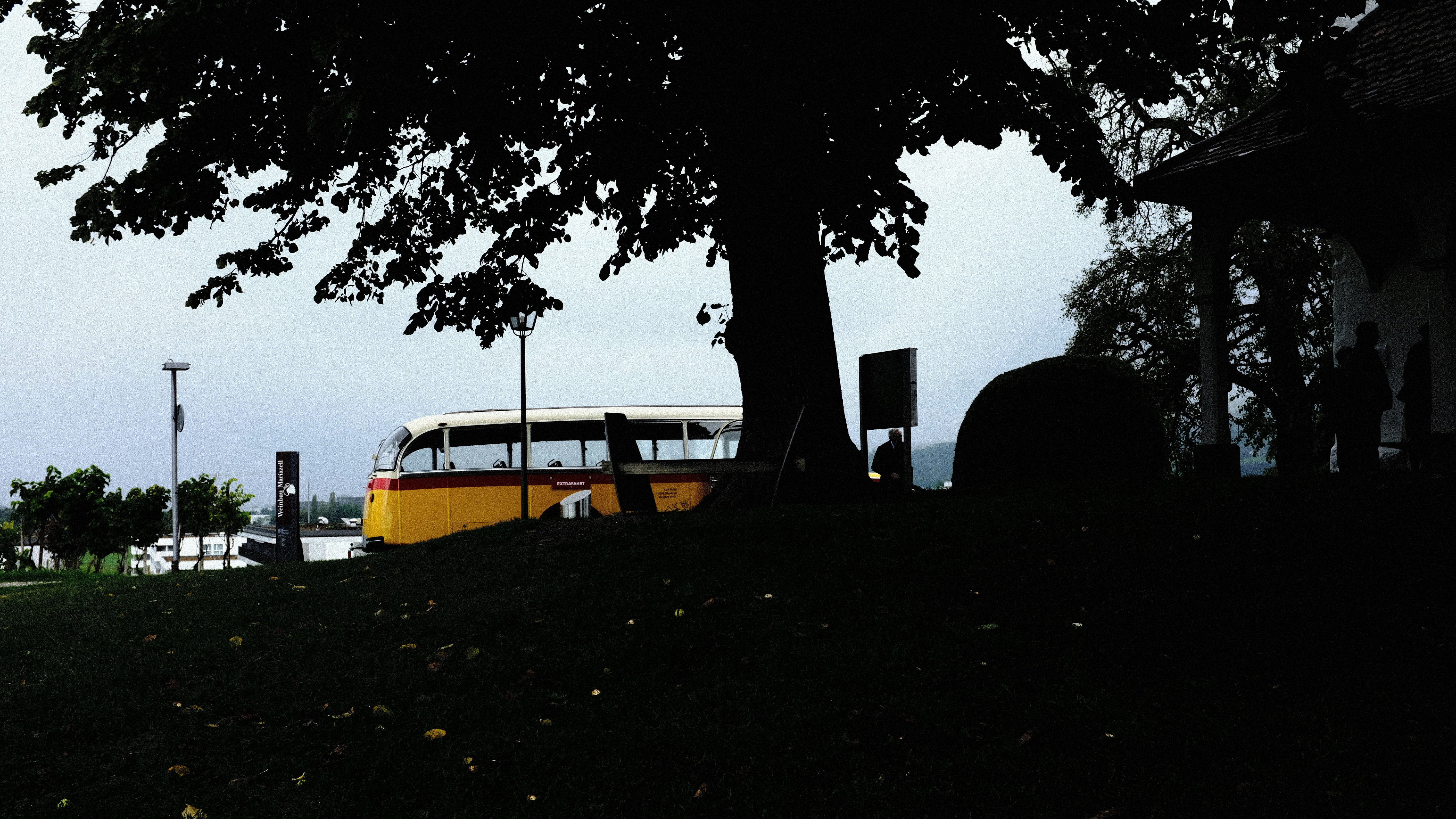 Dusk Quiet by the Park: A Vintage Yellow Bus Hidden in Shadow