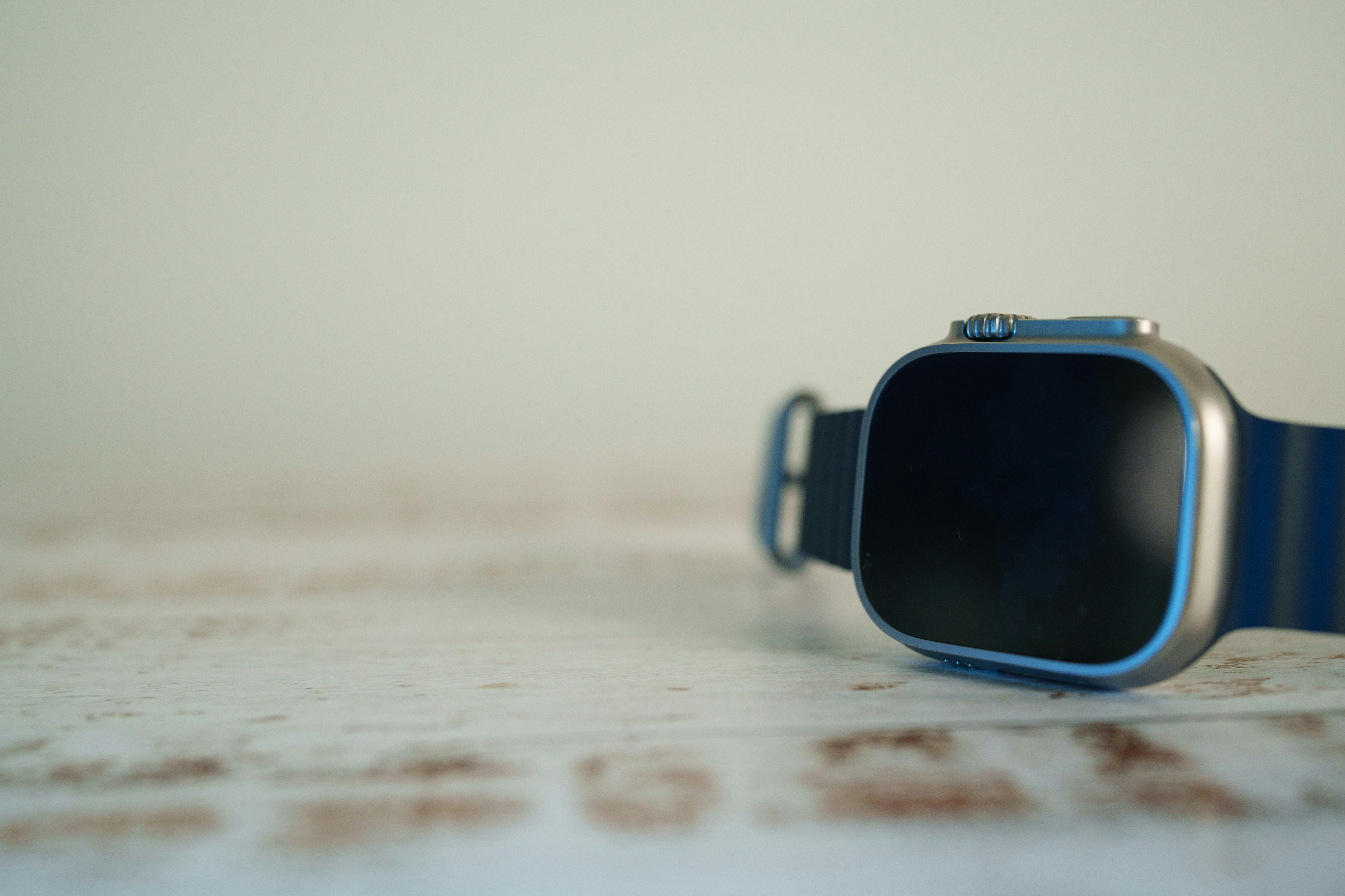 Cobalt Smartwatch at the Edge of Focus on a Weathered Table